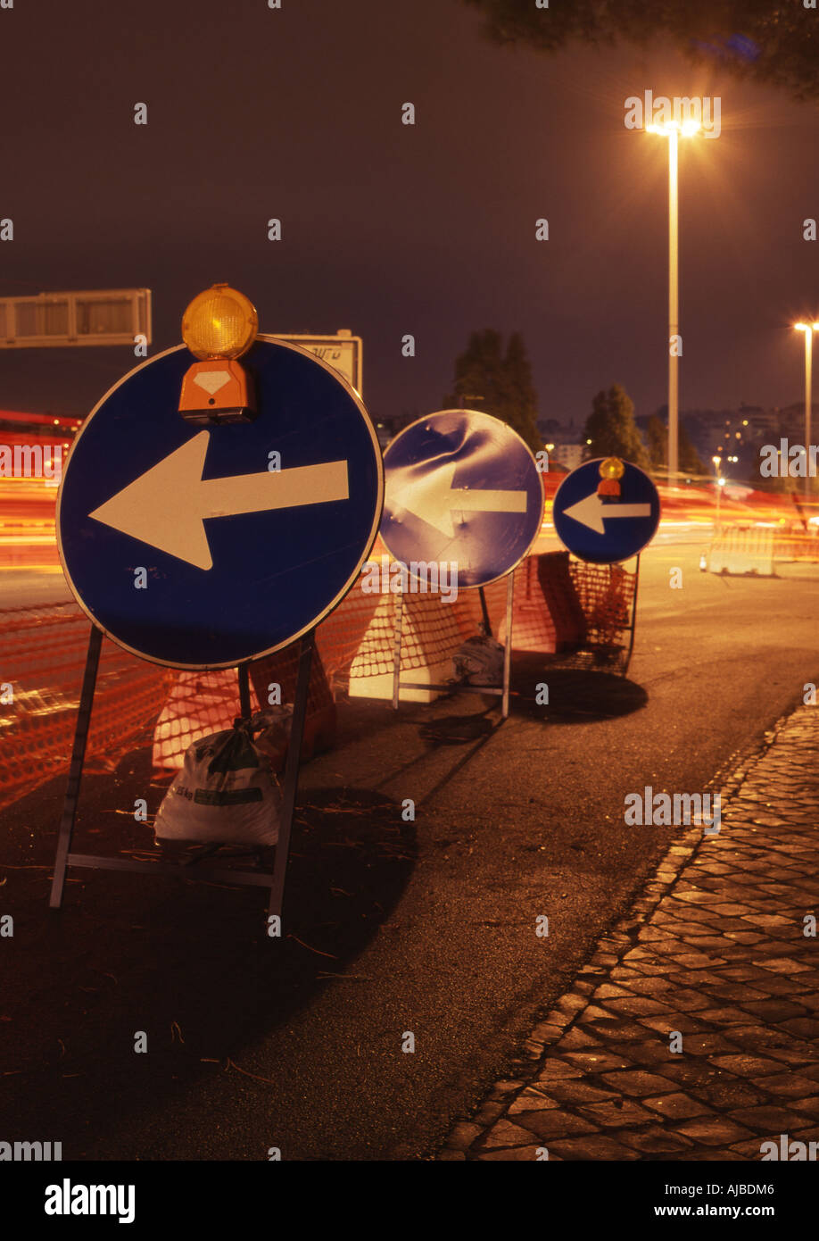 road works and arrows on busy road at night Stock Photo - Alamy