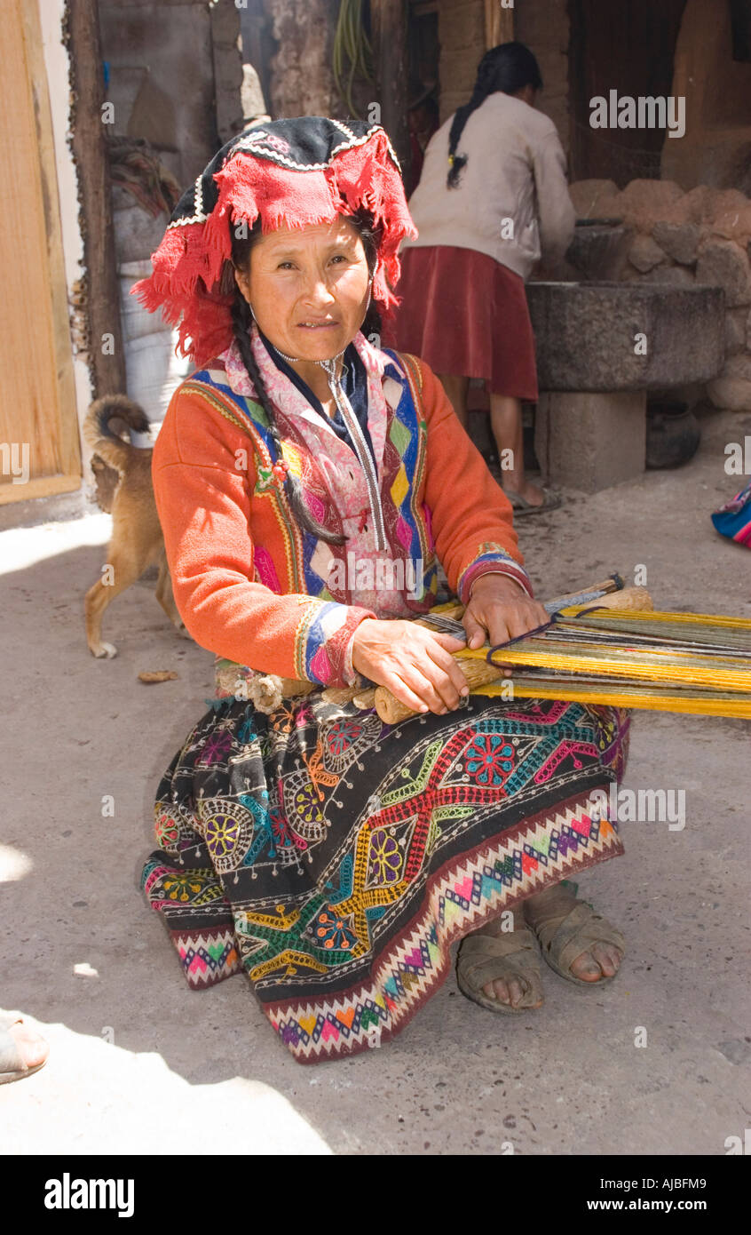 Traditional Peruvian woman in local costume weaving textiles in Pisac ...