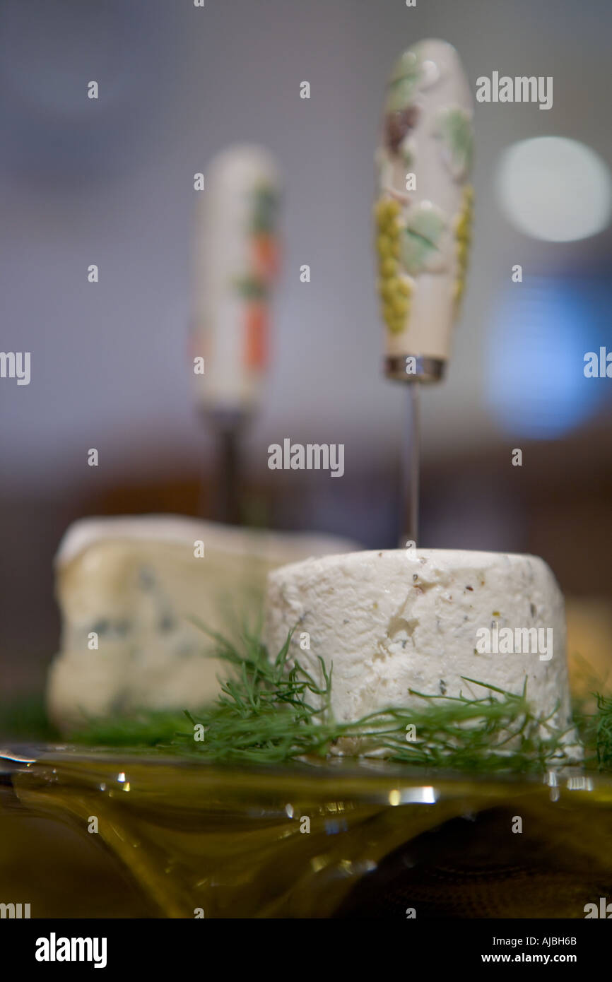 Close up still life of peppered goat cheese with knife stuck in it ...