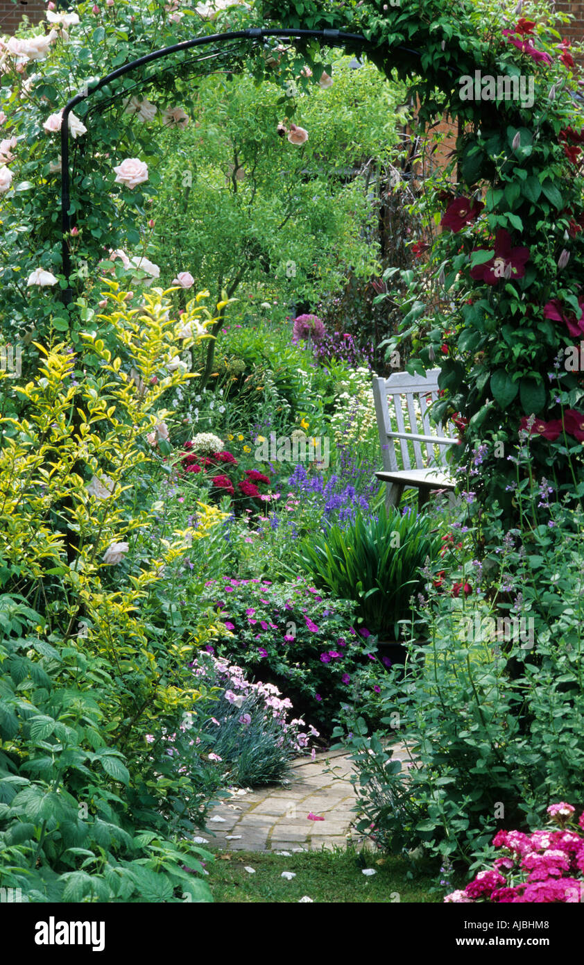 Clematis rose arch brick path cottage garden Stock Photo - Alamy