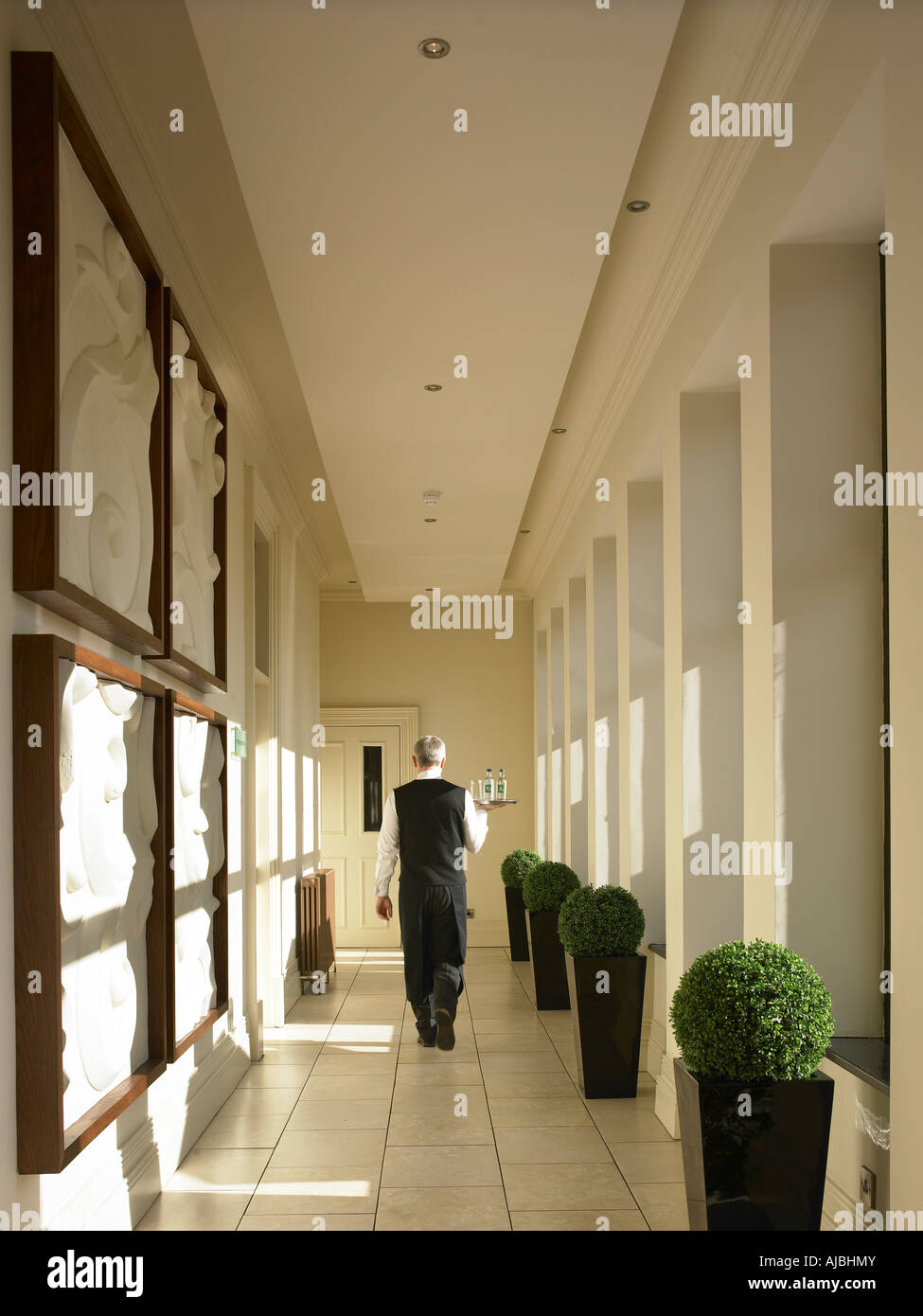 Waiter walking down a hall Stock Photo - Alamy