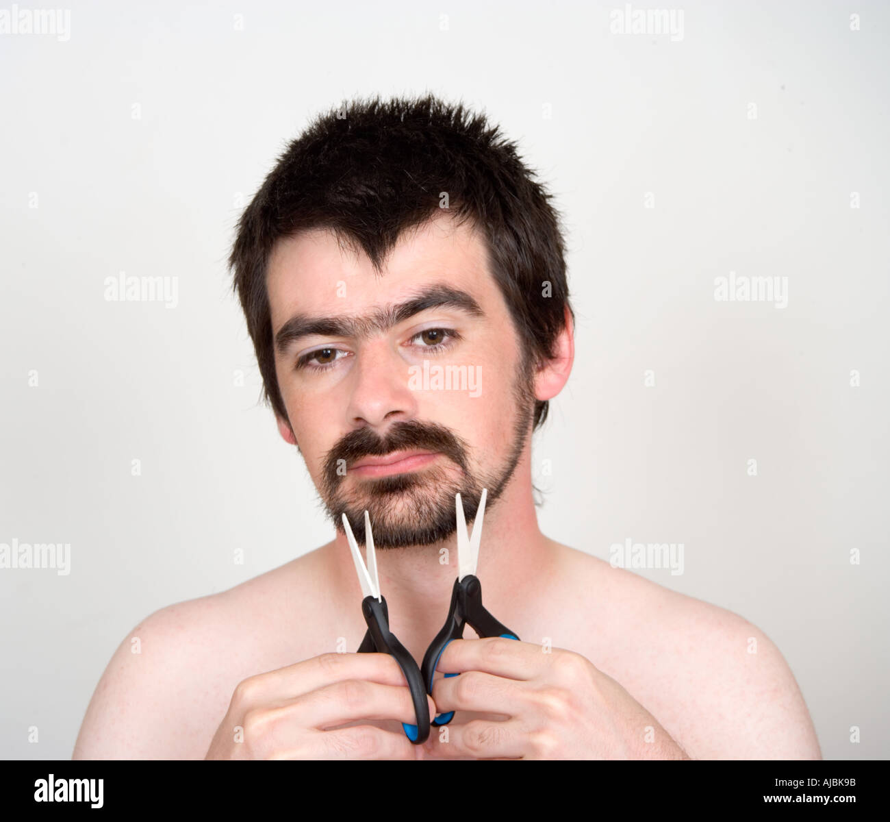 Man with two pairs of scissors trimming beard Stock Photo - Alamy