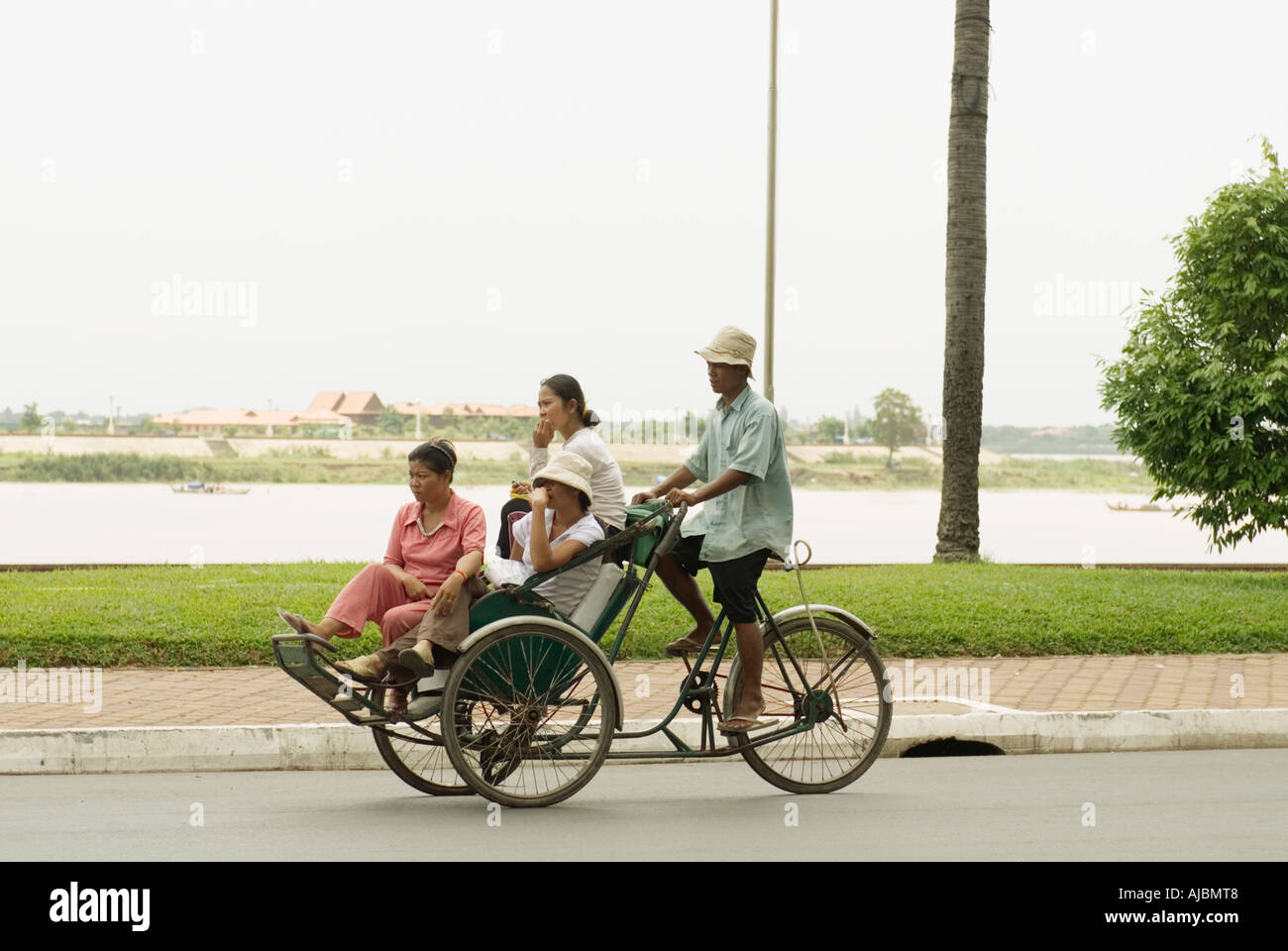 Cambodia Phnom Penh Man Pedaling A Rickshaw With Passengers Stock Photo ...