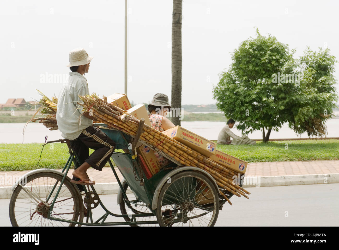 Cambodia Phnom Penh Man Pedaling A Rickshaw With Passenger And Goods ...