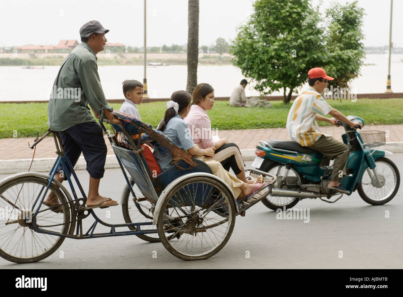 Cambodia Phnom Penh Man Pedaling A Rickshaw With Passengers Stock Photo ...