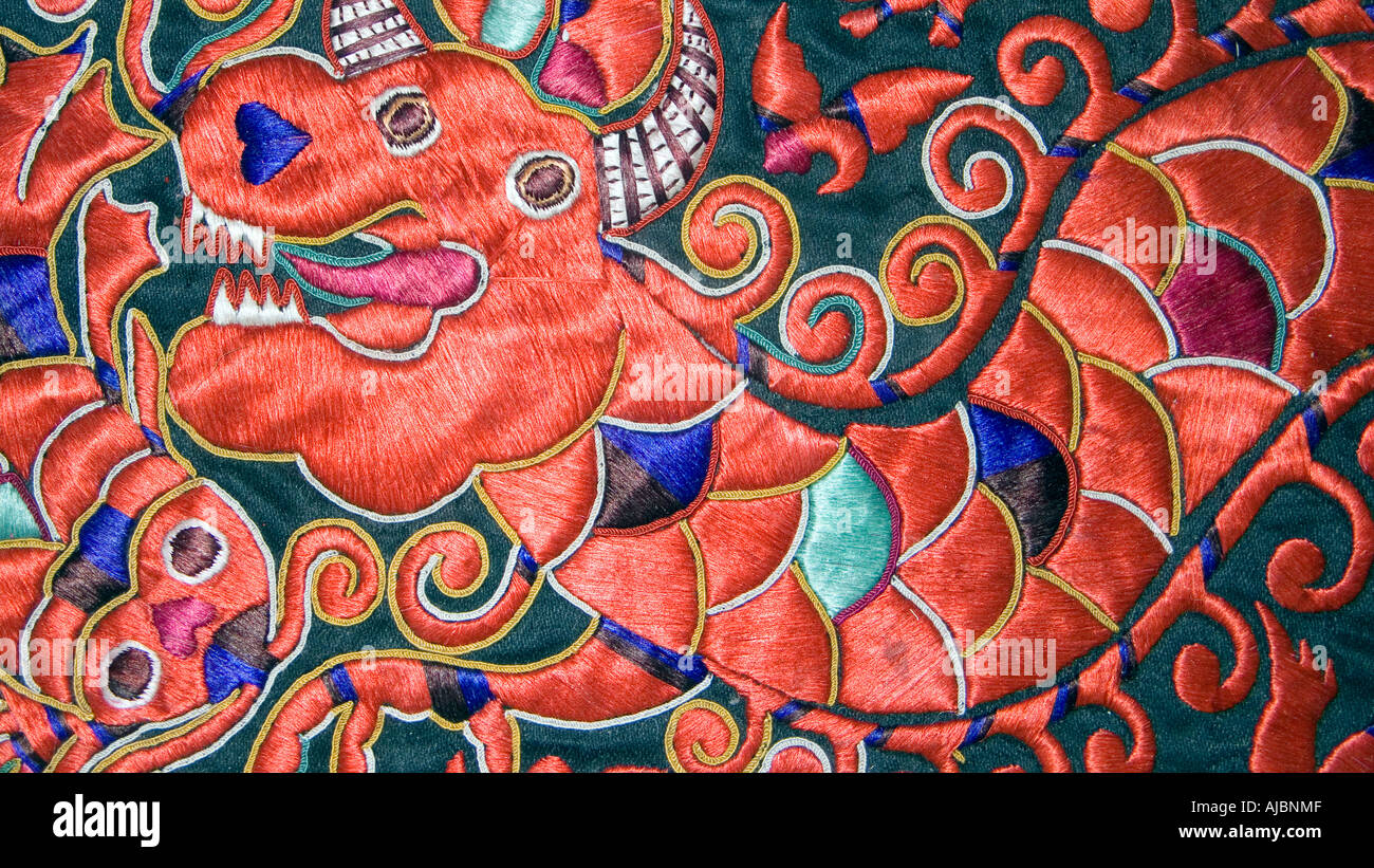 Ornately embroidered Tibetan garment depicting a dragon in red silk ...