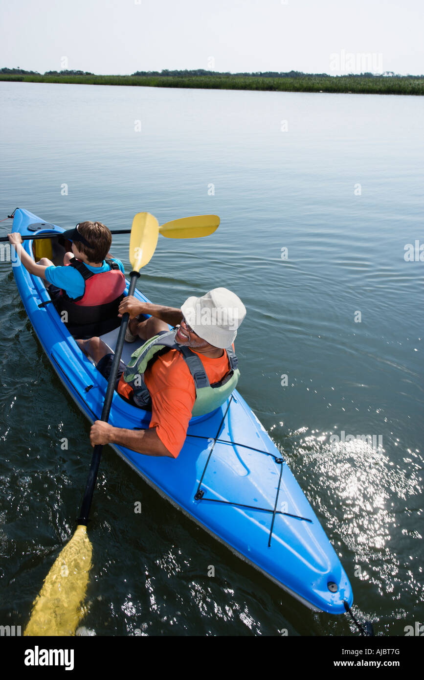 Back view of African American middle aged couple paddling kayak Stock ...