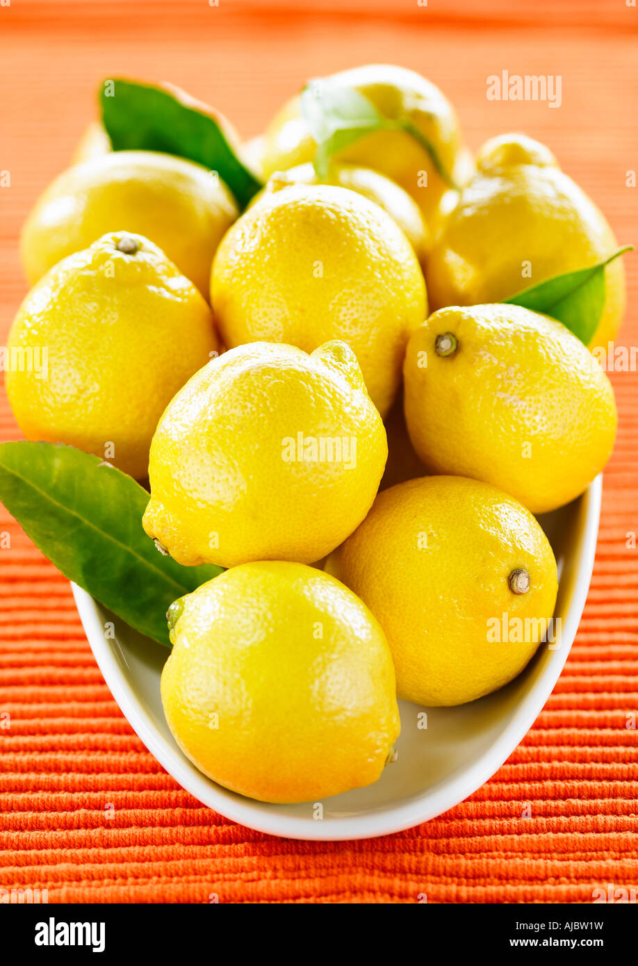Large Bowl of Shiny Lemons with Orange Background Stock Photo - Alamy