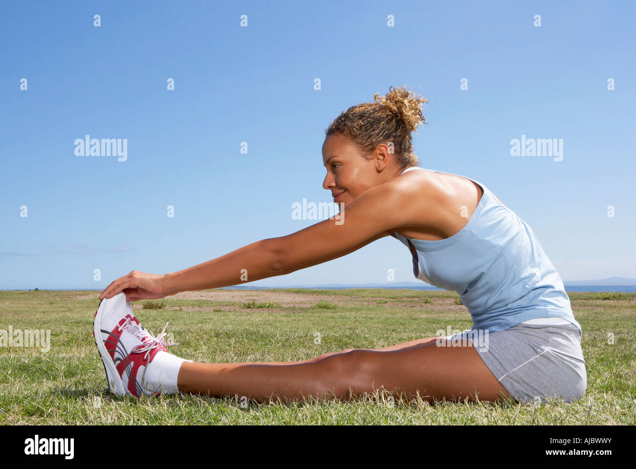 Profile of a Female Athlete Stretching her Hamstrings Stock Photo - Alamy