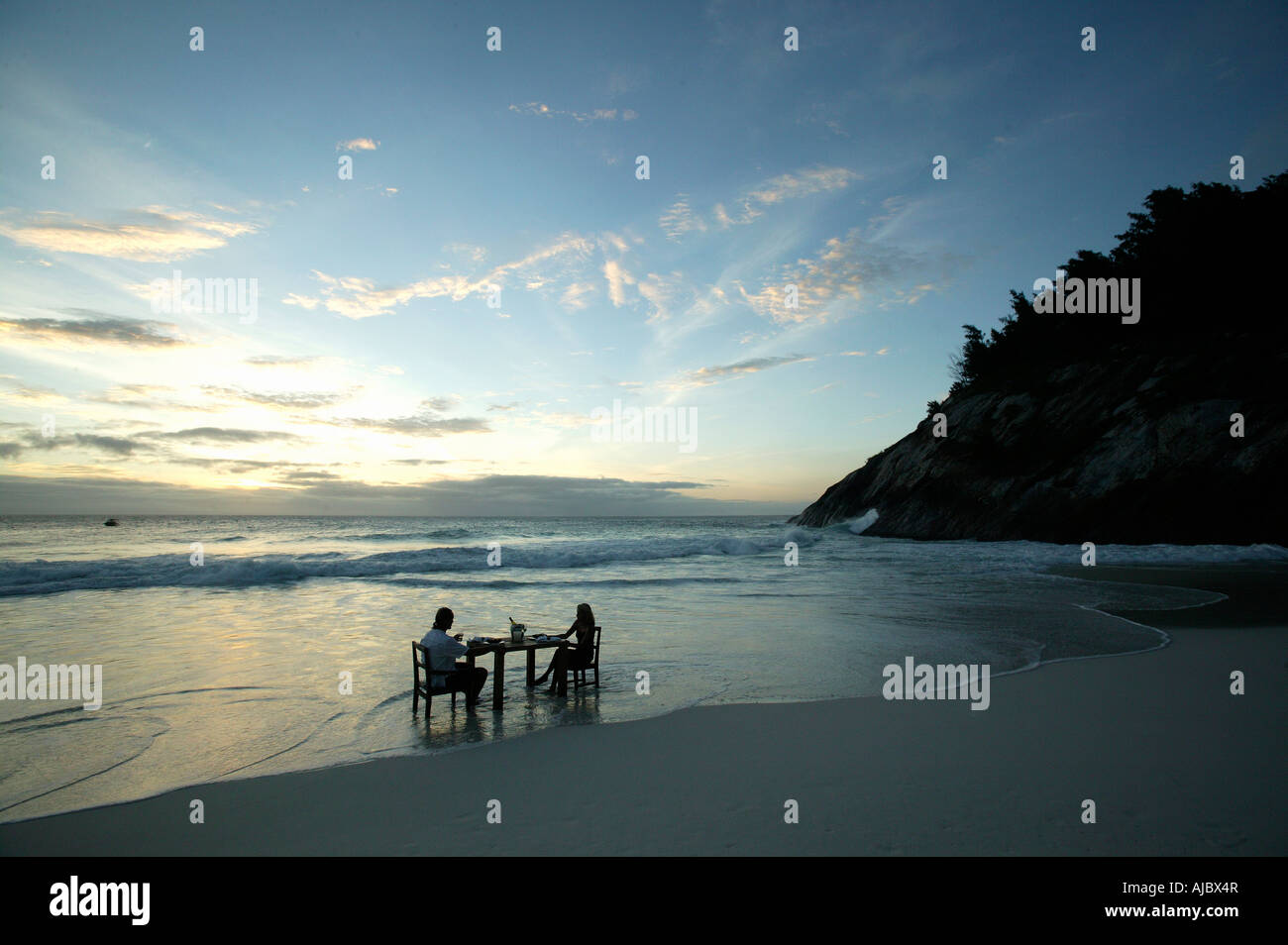 Couple Enjoying Sundowners on the Beach at Sunset Stock Photo - Alamy
