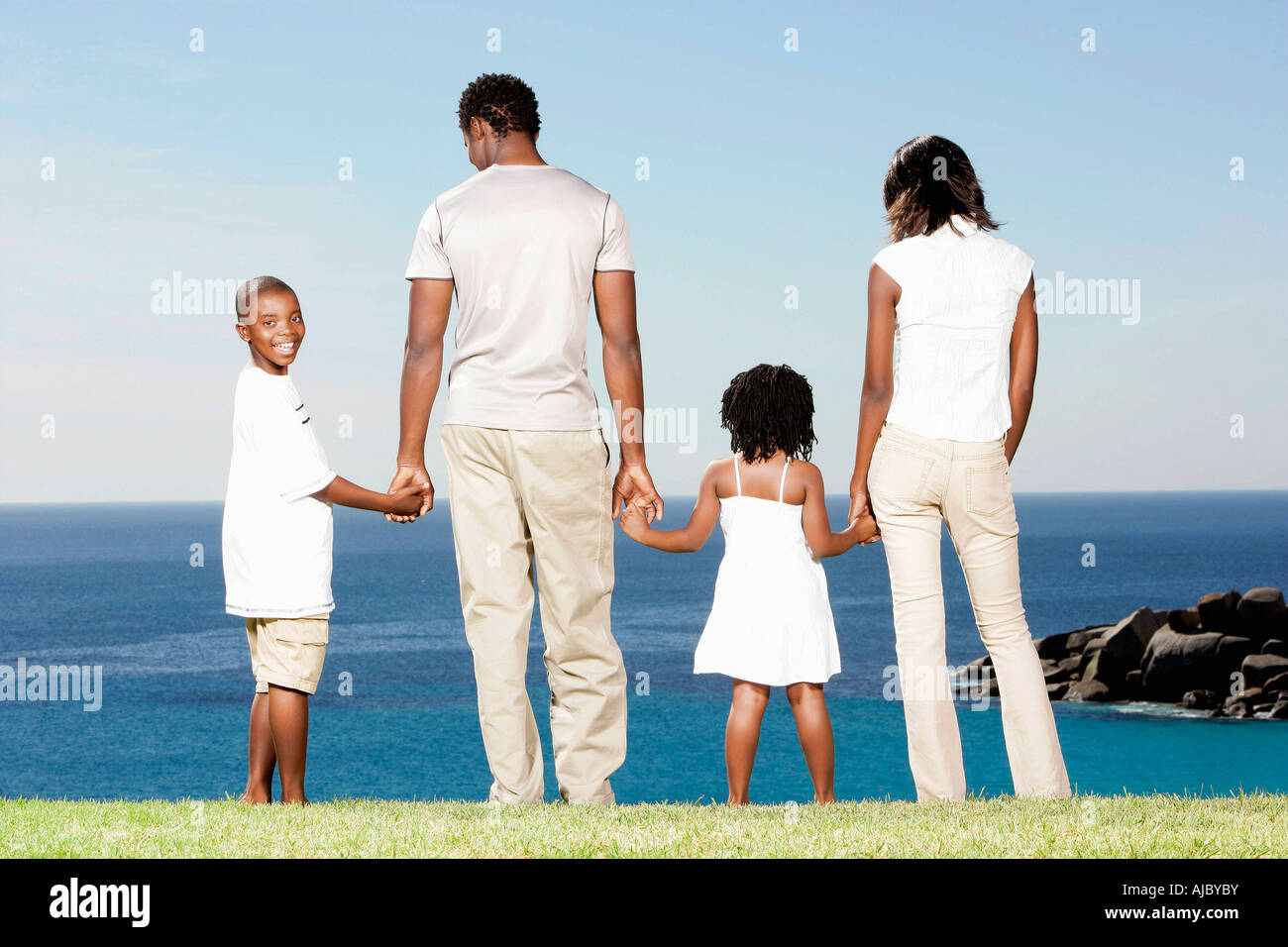 Young African Family Looking Out to Sea - Rear View Stock Photo - Alamy