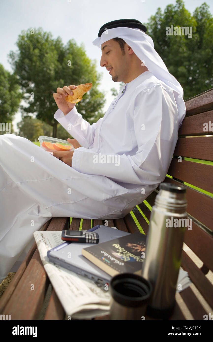 Arab Man Eating Lunch on Park Bench Stock Photo - Alamy