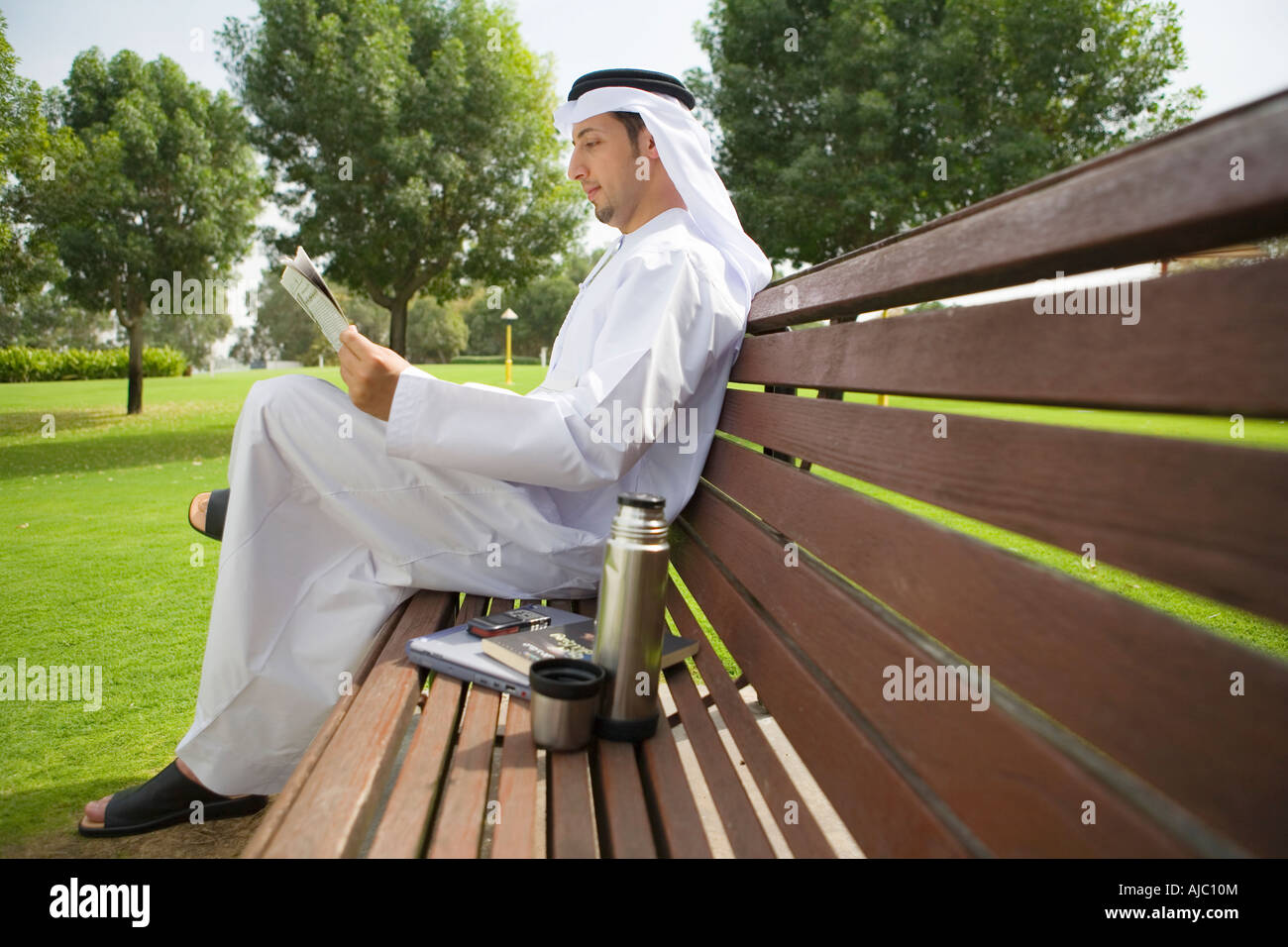 Arab Man Reading Newspaper on Park Bench Stock Photo - Alamy