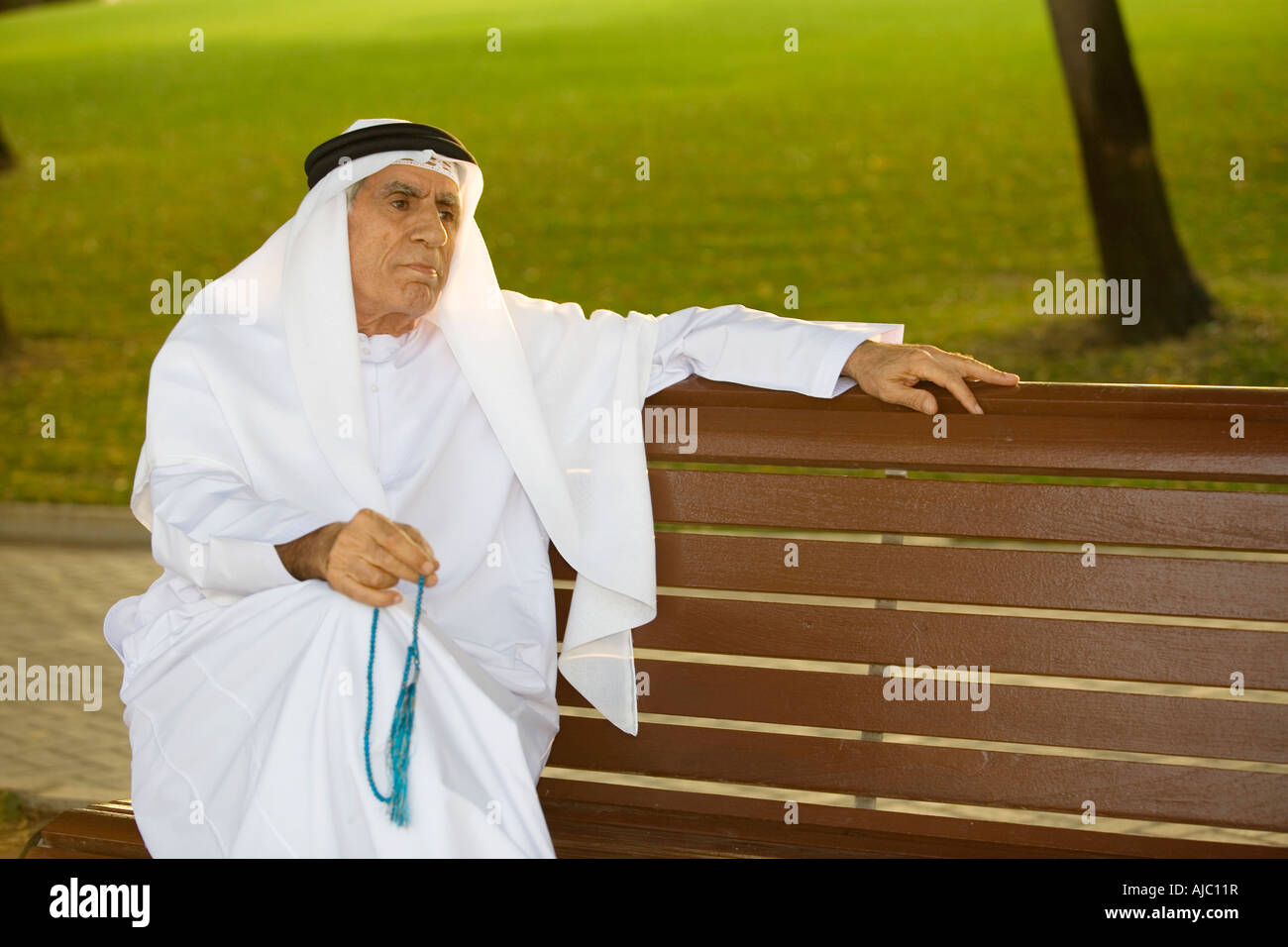 Elderly Arabic Man Sitting on Bench with Prayer Beads in Park Stock ...