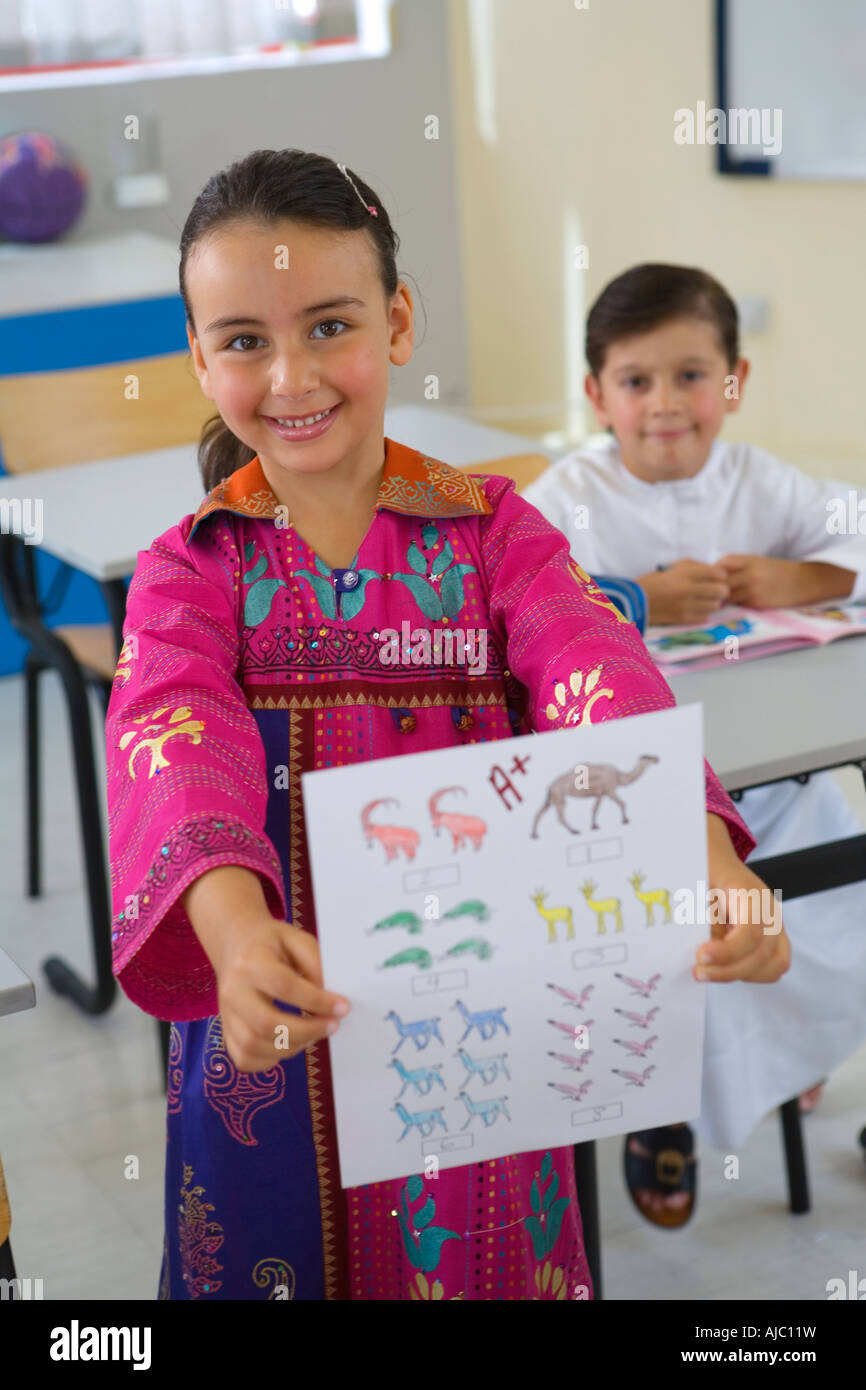 Smiling Girl Holding Homework in Classroom, Front View Stock Photo - Alamy