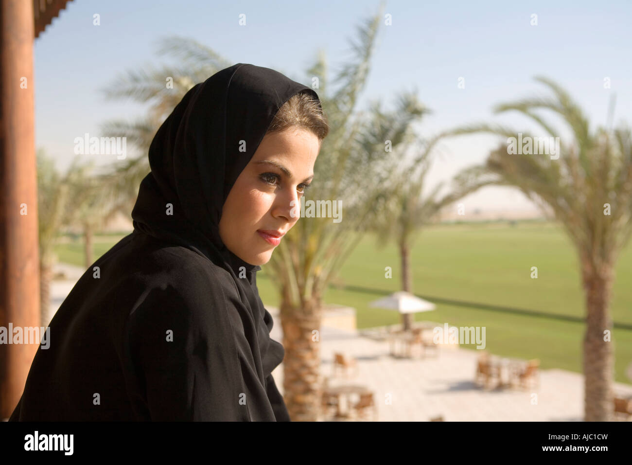 Arab Woman Standing on Balcony, Staring into Distance, Side View Stock ...