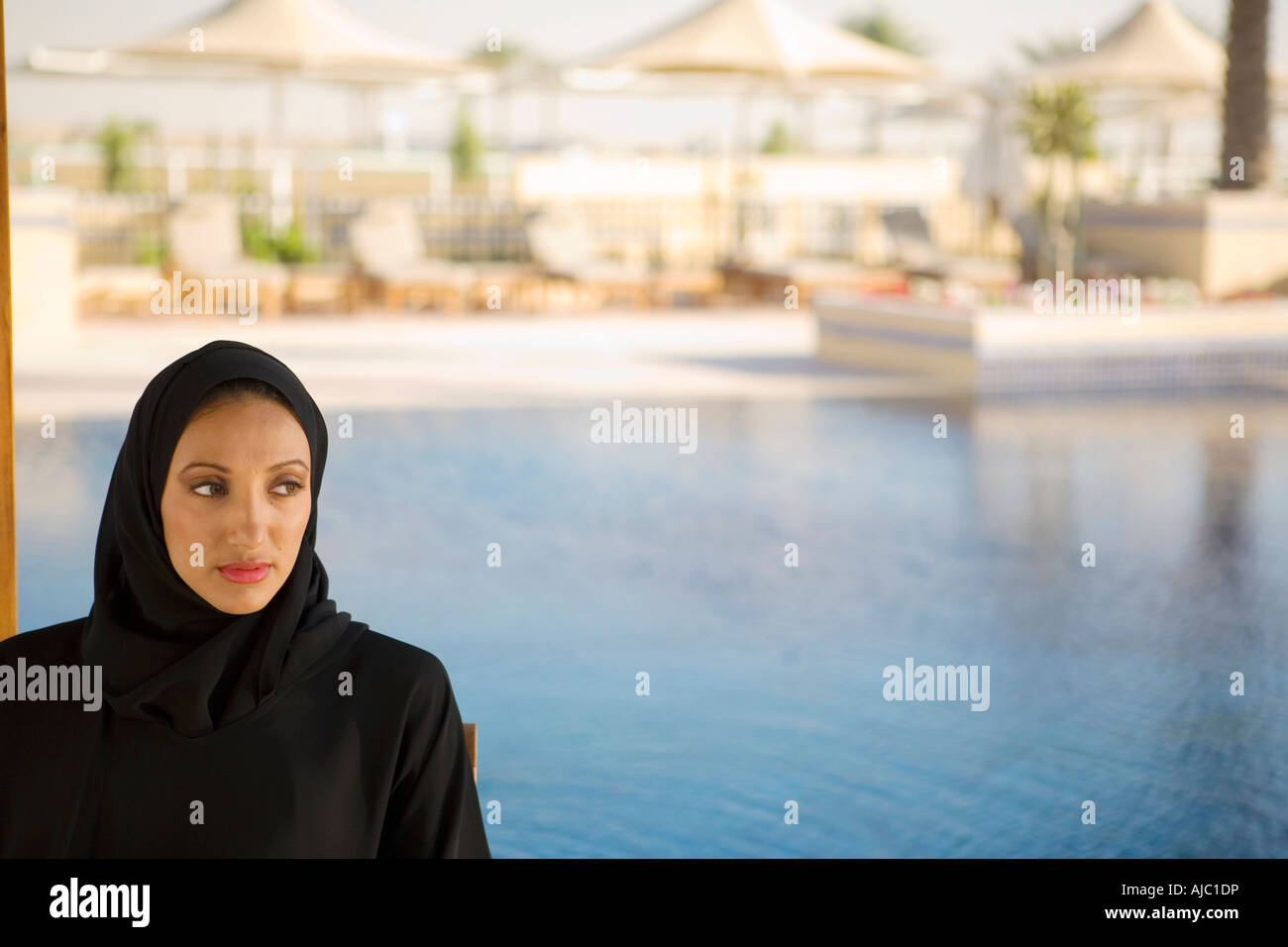 Woman sitting beside pool hi-res stock photography and images - Alamy