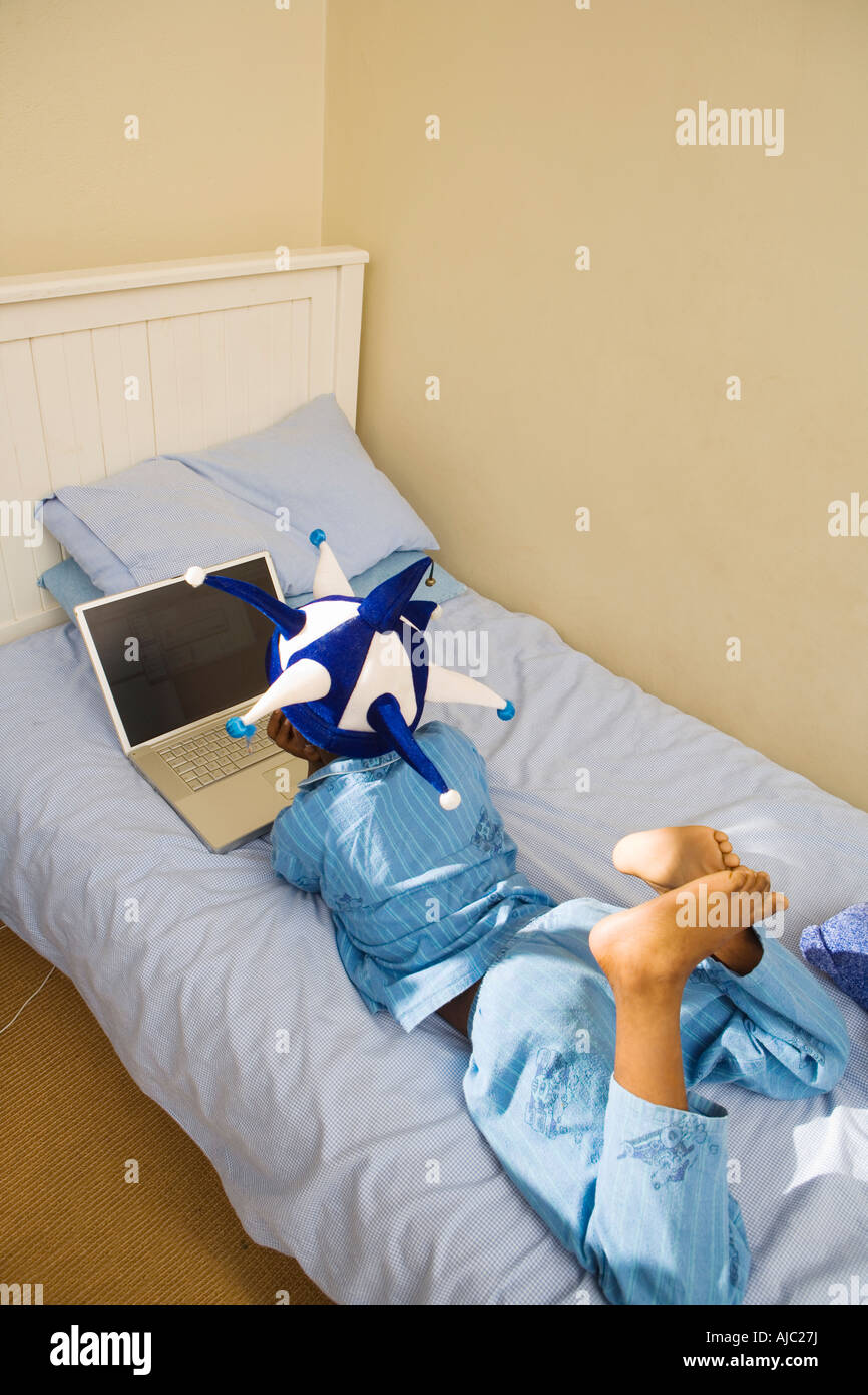 Young African Boy Using a Laptop Computer on his Bed Stock Photo - Alamy