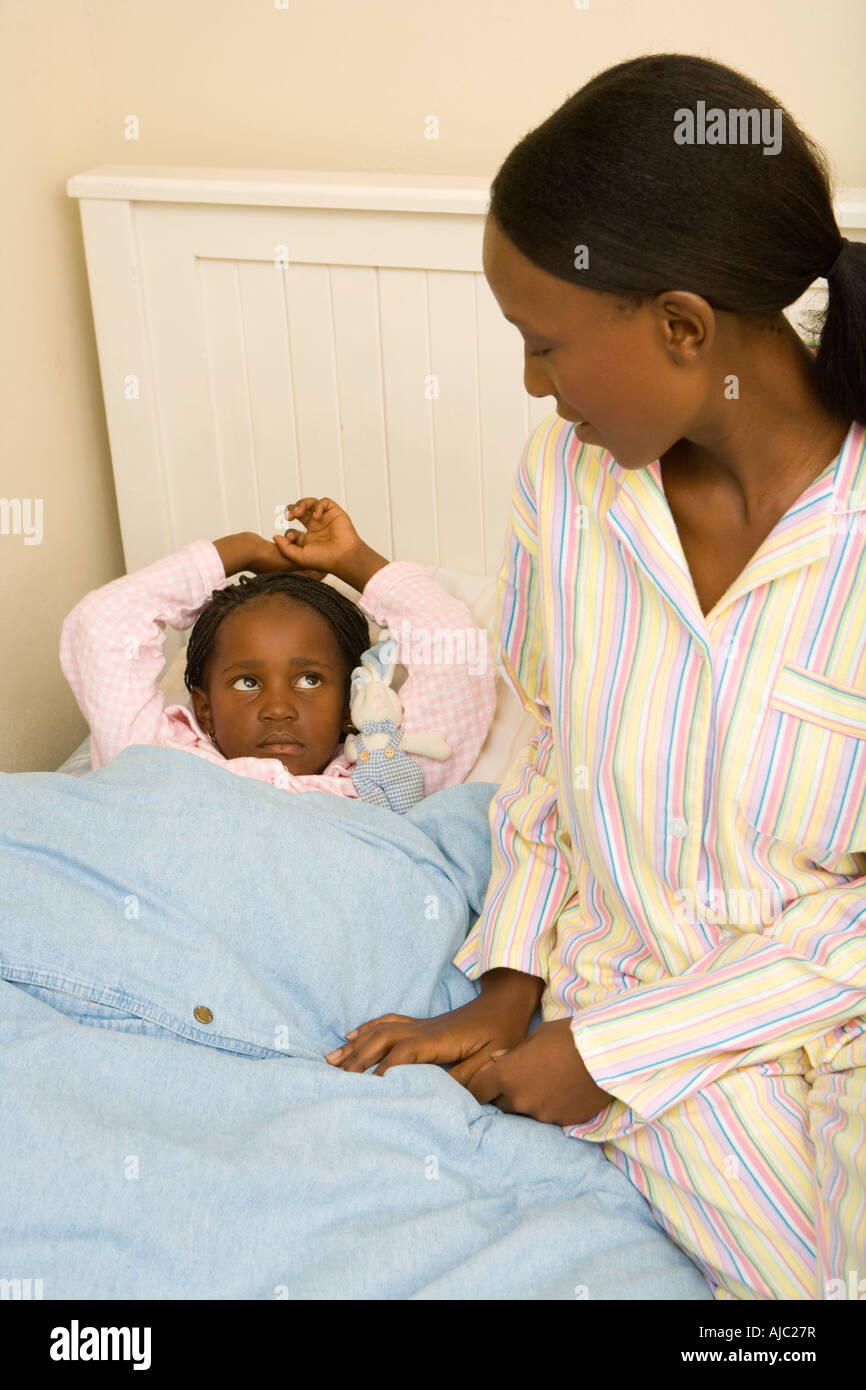 African Woman Tucking her Daughter into Bed Stock Photo - Alamy
