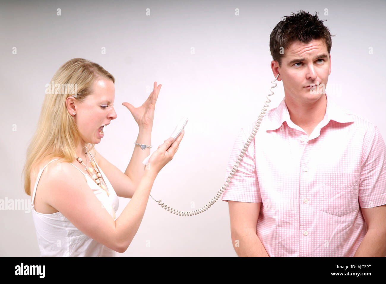 Woman Screaming Down a Phone Connected to a Man Stock Photo - Alamy