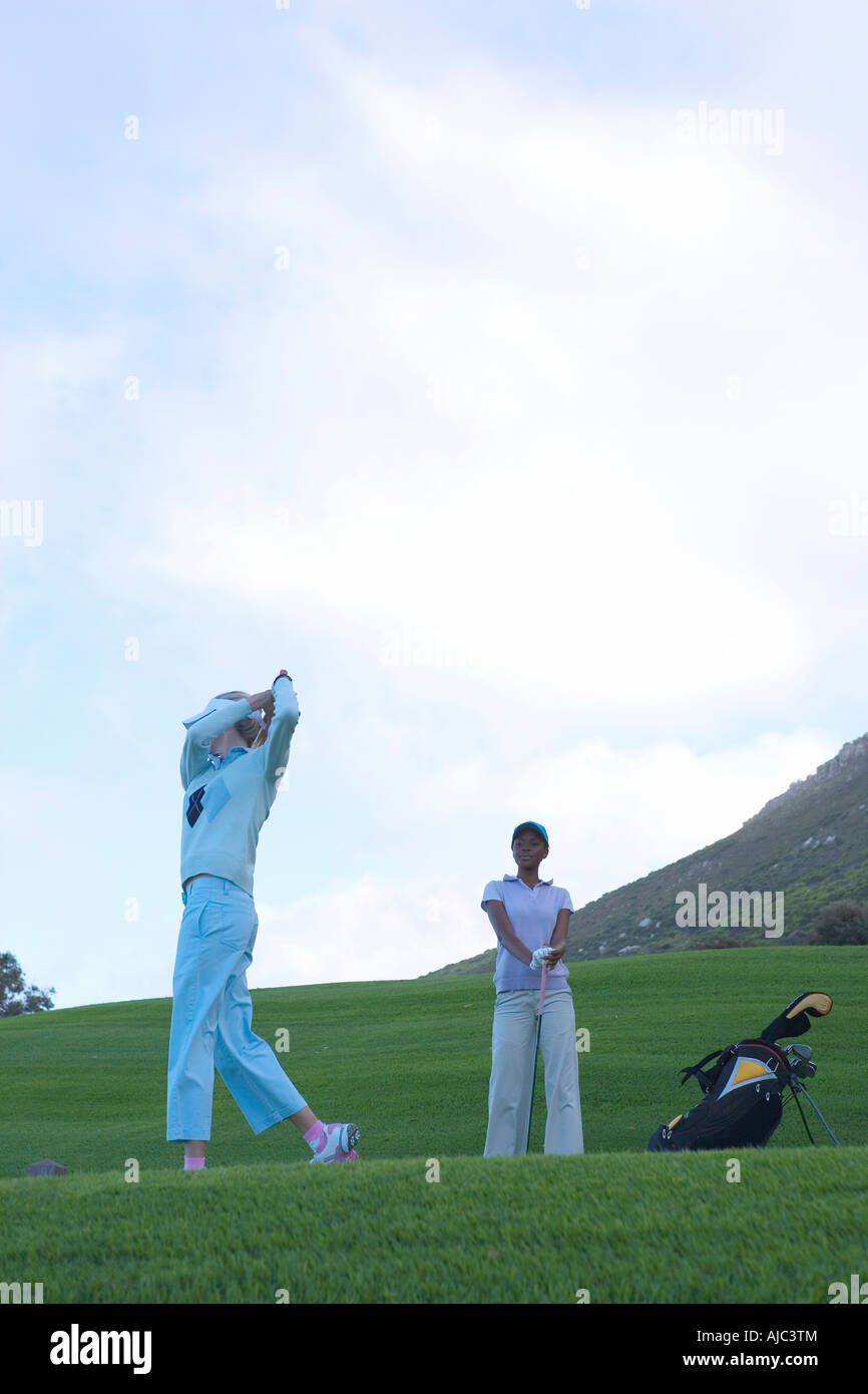 Side View of Woman Swinging Golf Club Stock Photo - Alamy