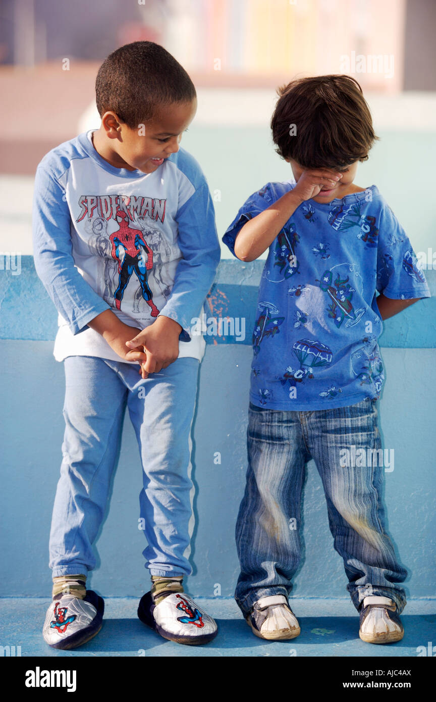 Two Young Children Standing Against a Wall Stock Photo - Alamy
