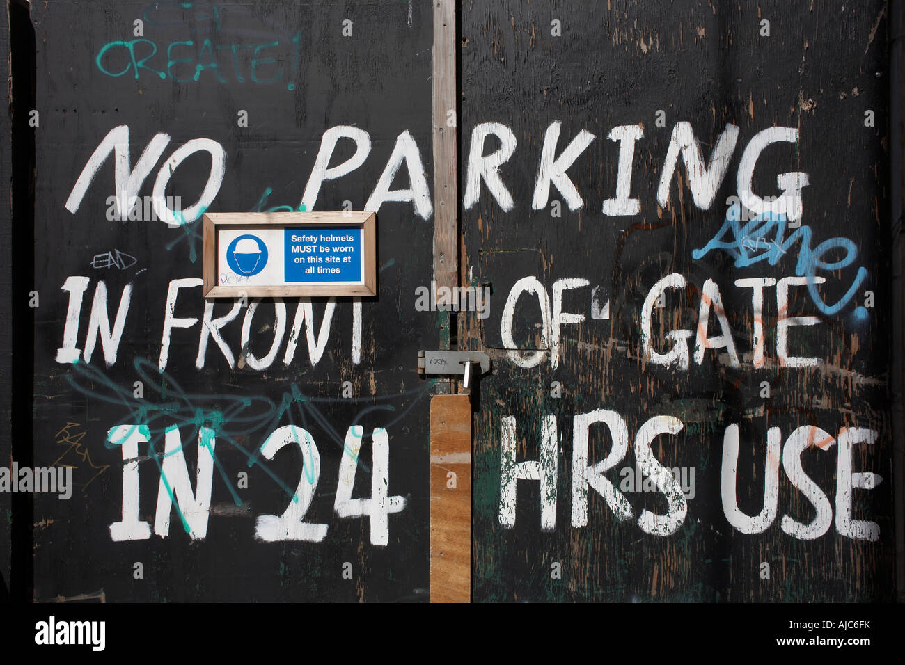 A makeshift sign on a house's gate with graffiti tells car drivers No ...