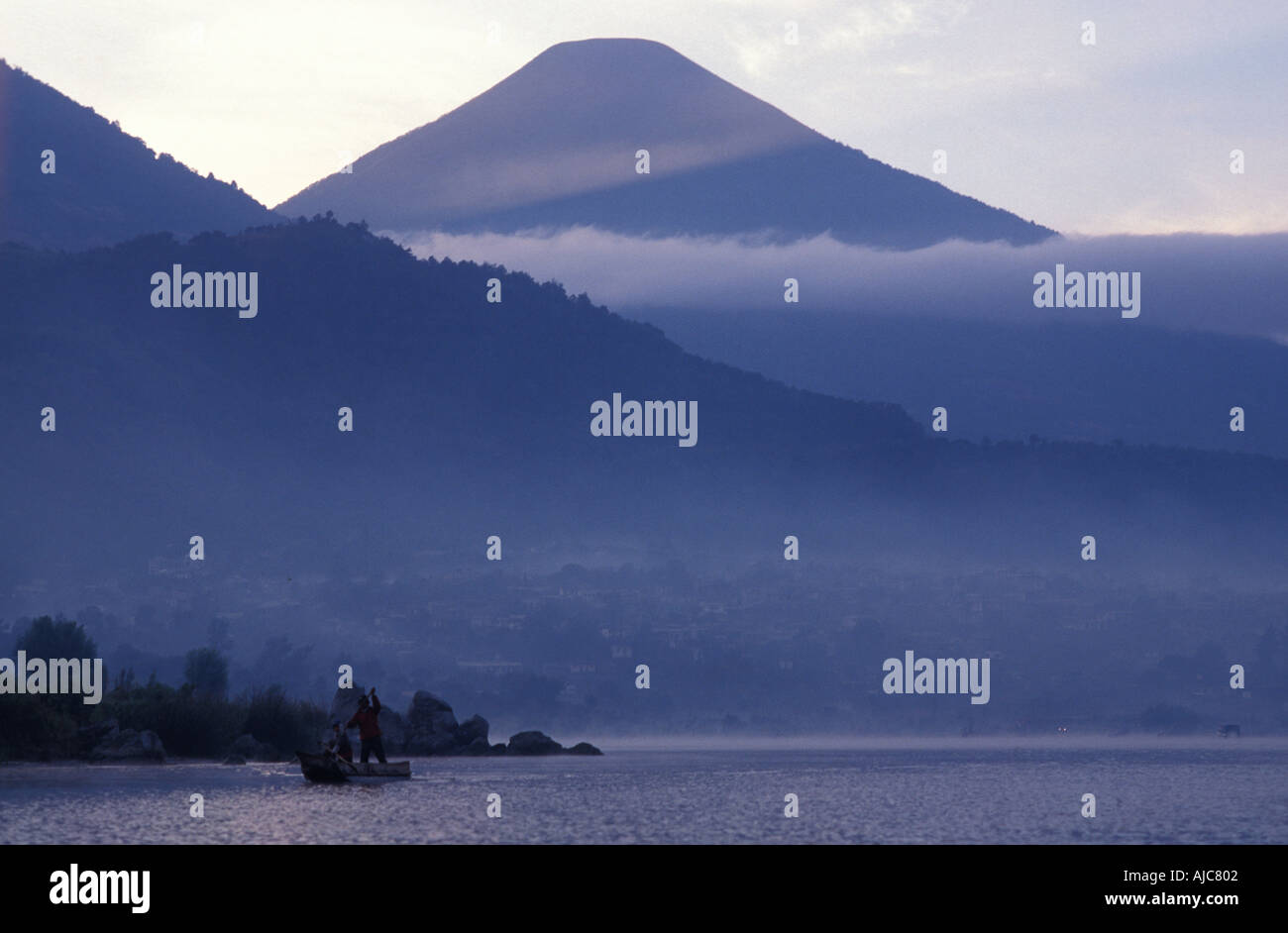 Santiago Atitlan sits beneath the towering peak of Toliman volcano Lake ...