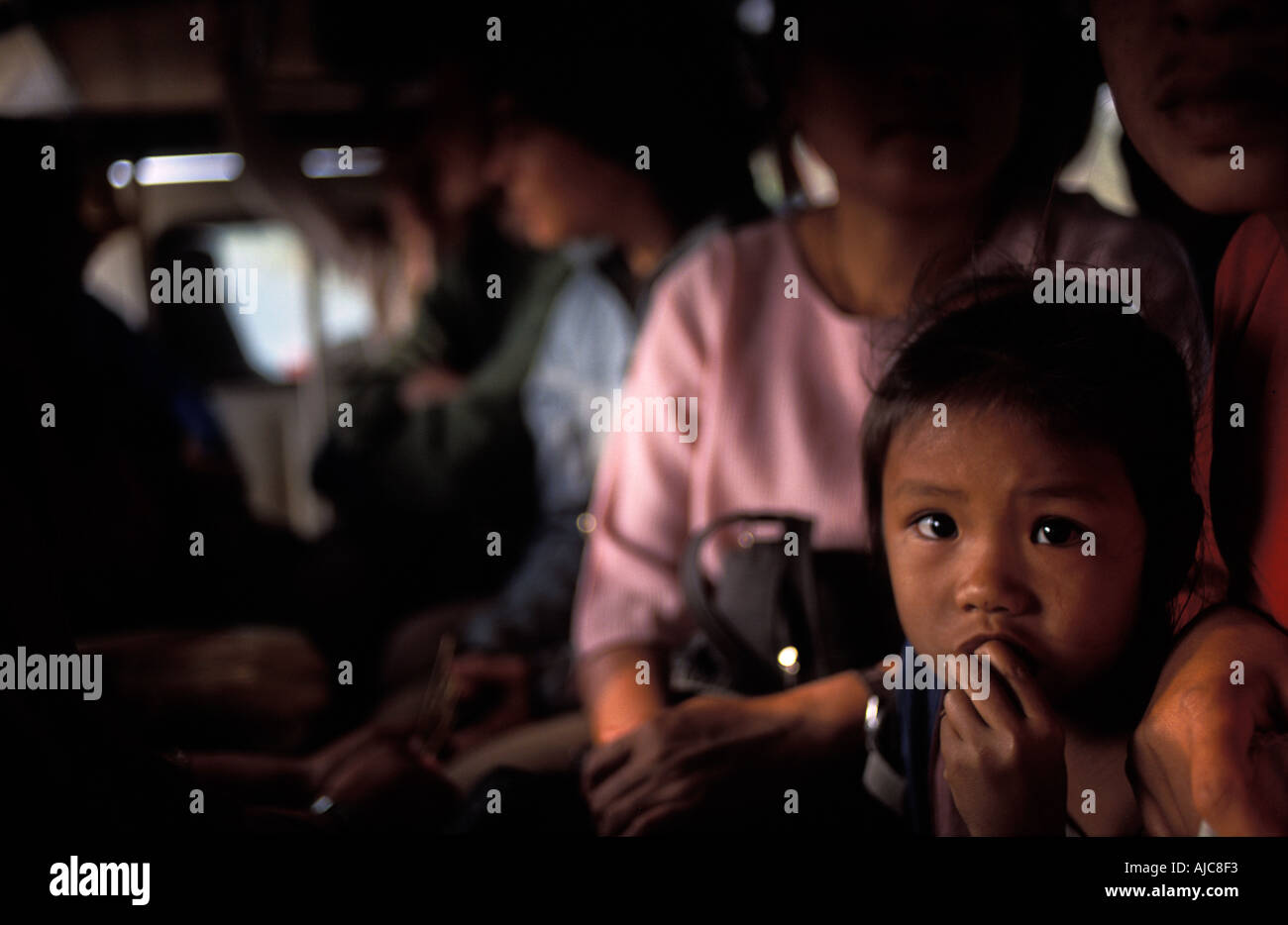 Shy youngster squeezed into the back of a songthaew converted pick up ...
