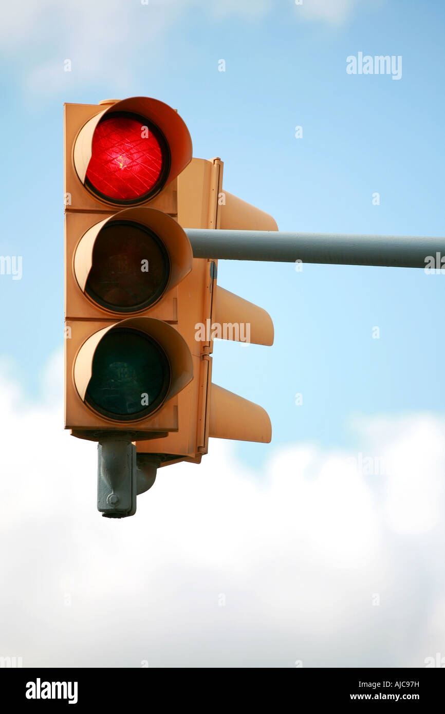 A Overhead traffic light in yellow against a blue clouded sky with the ...