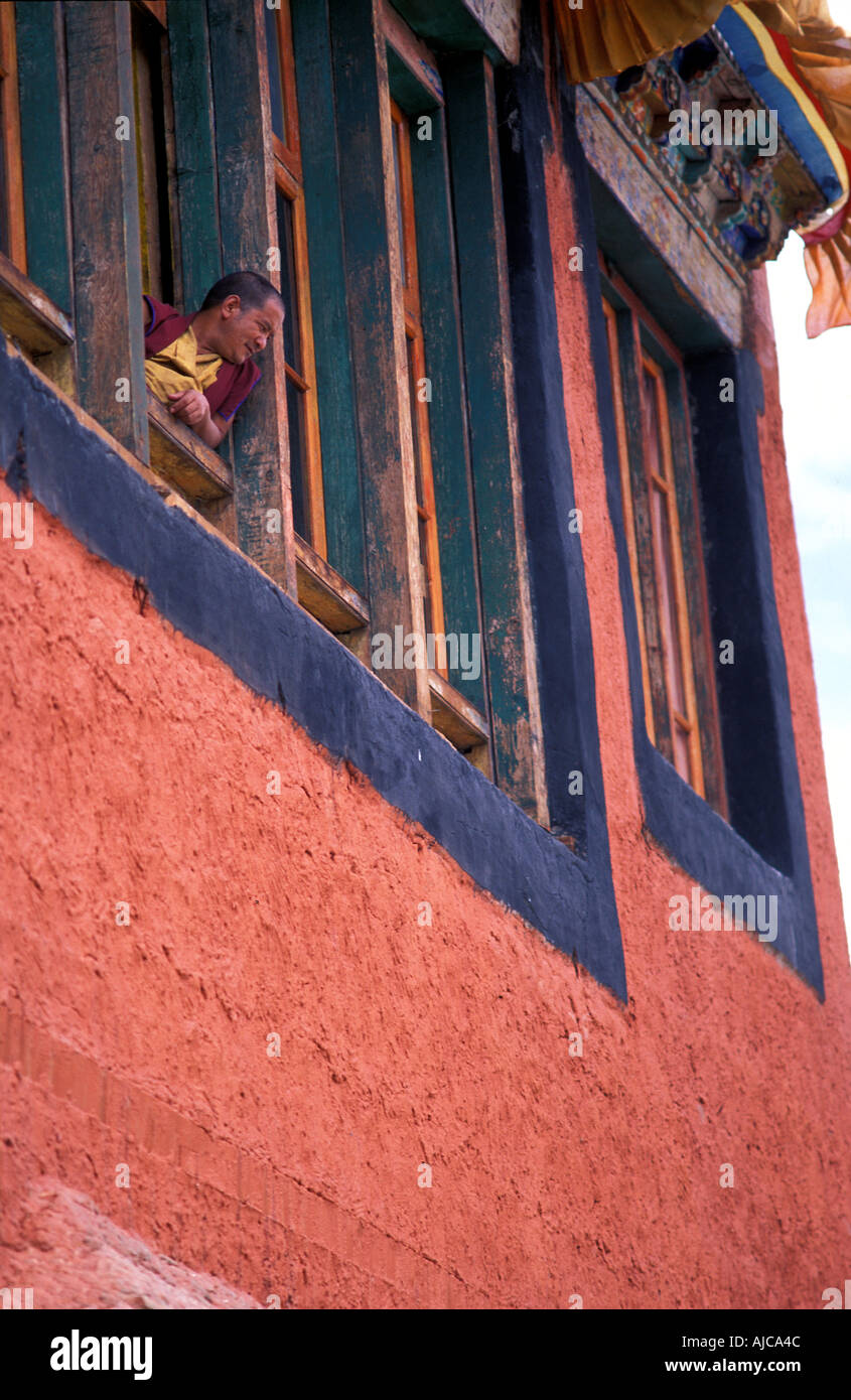 Monk leaning from the window of the great hall Thikse Monastery Ladakh ...