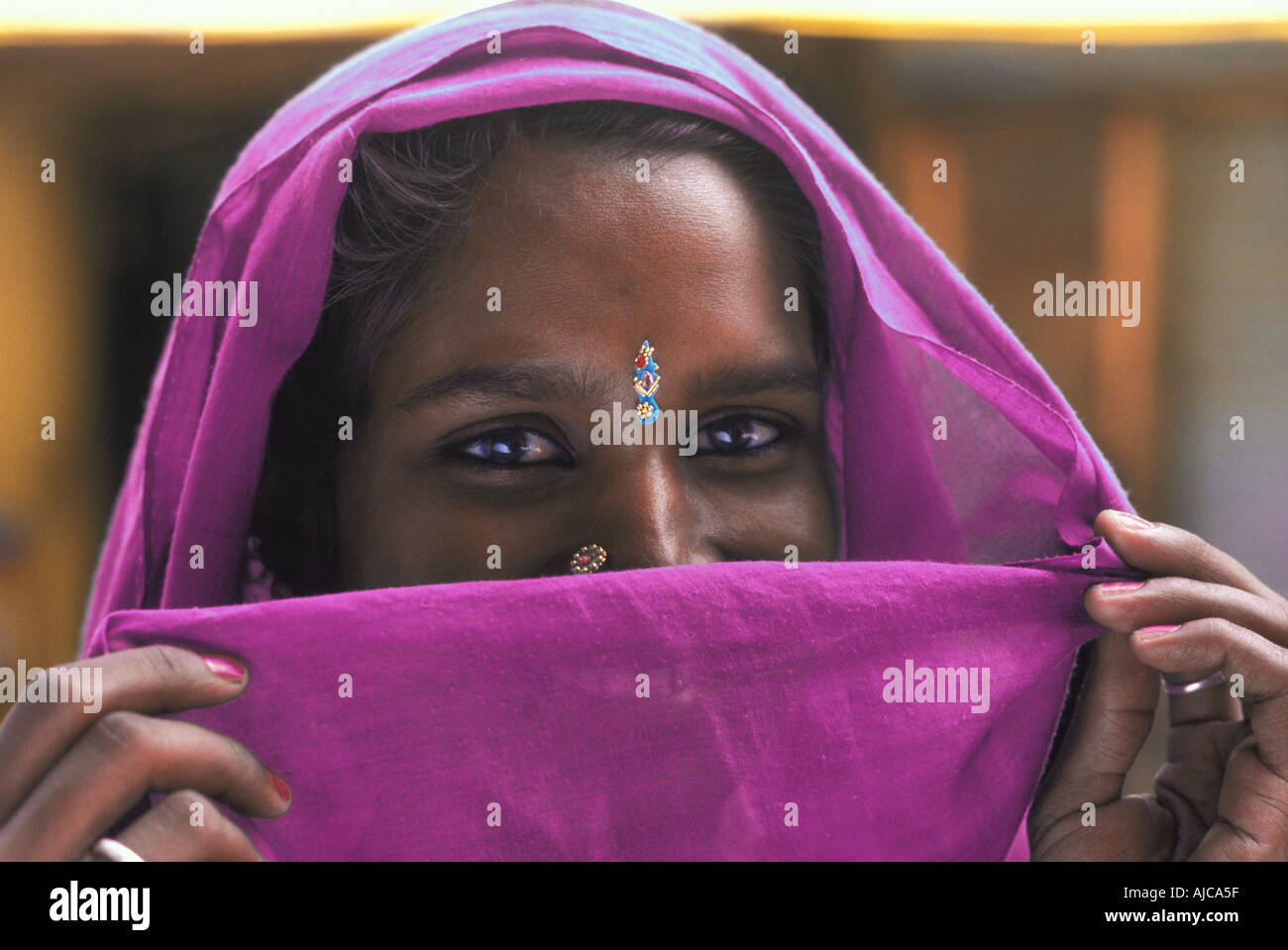 Friendly Hindu woman from Uttar Pradesh with magenta headcloth veiling ...
