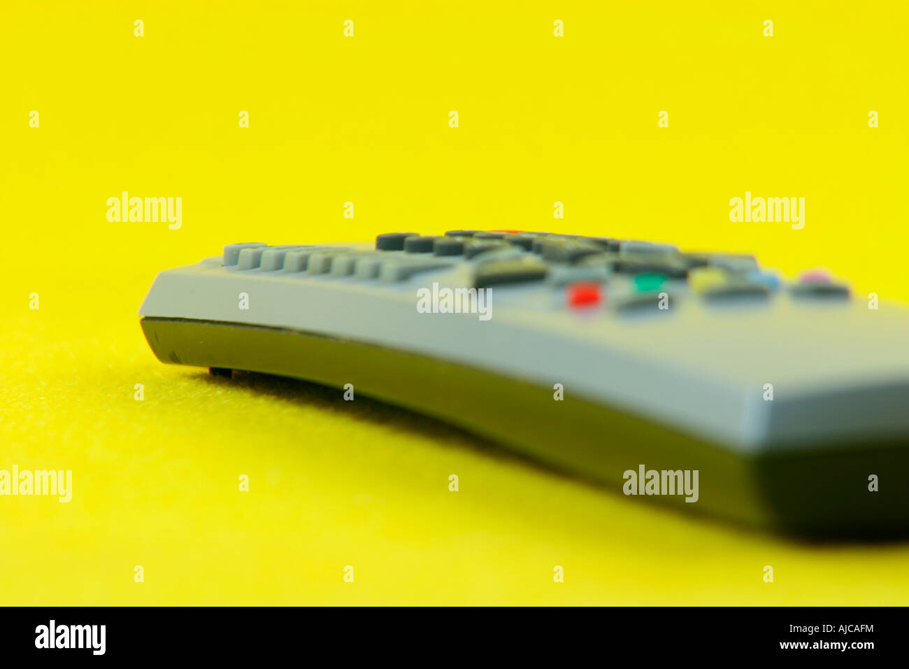 detail from television remote control in yellow background technology ...
