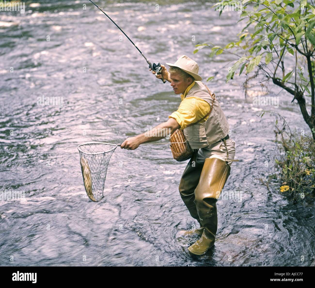 fisherman nets fish in stream Stock Photo - Alamy