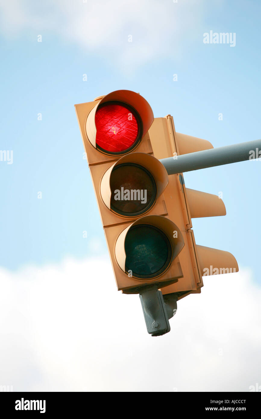 A Overhead traffic light in yellow against a blue clouded sky with the ...