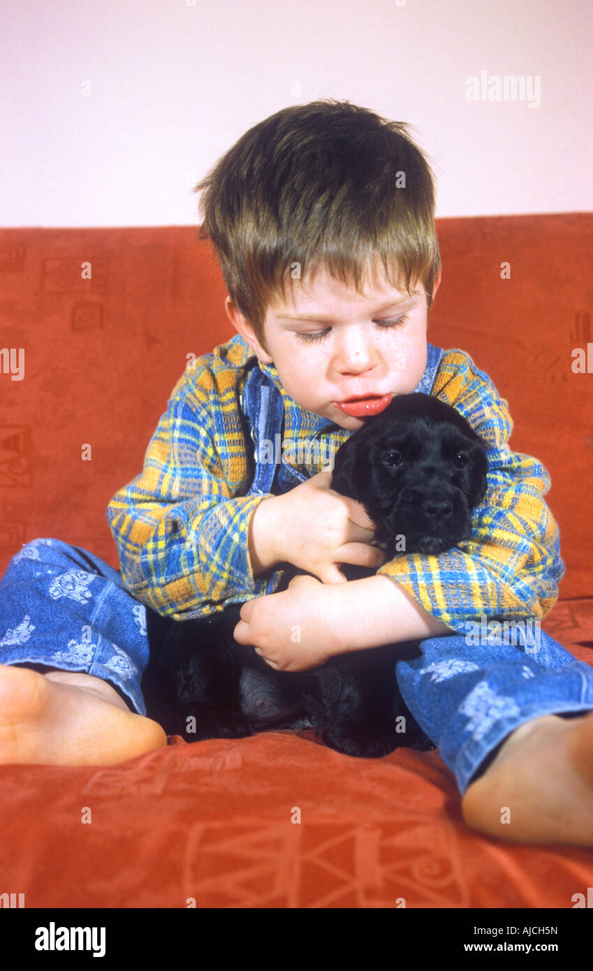 a young boy cuddling with his puppy Stock Photo - Alamy