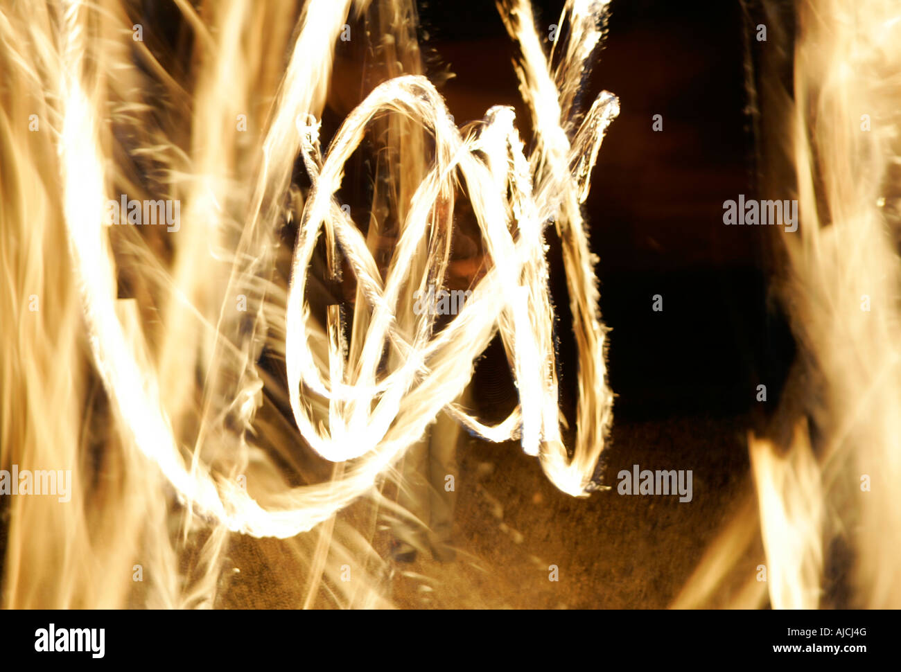 A woman performing with fire poi Stock Photo - Alamy