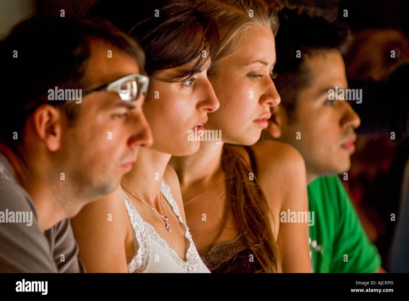 Four young people watching performance Stock Photo - Alamy