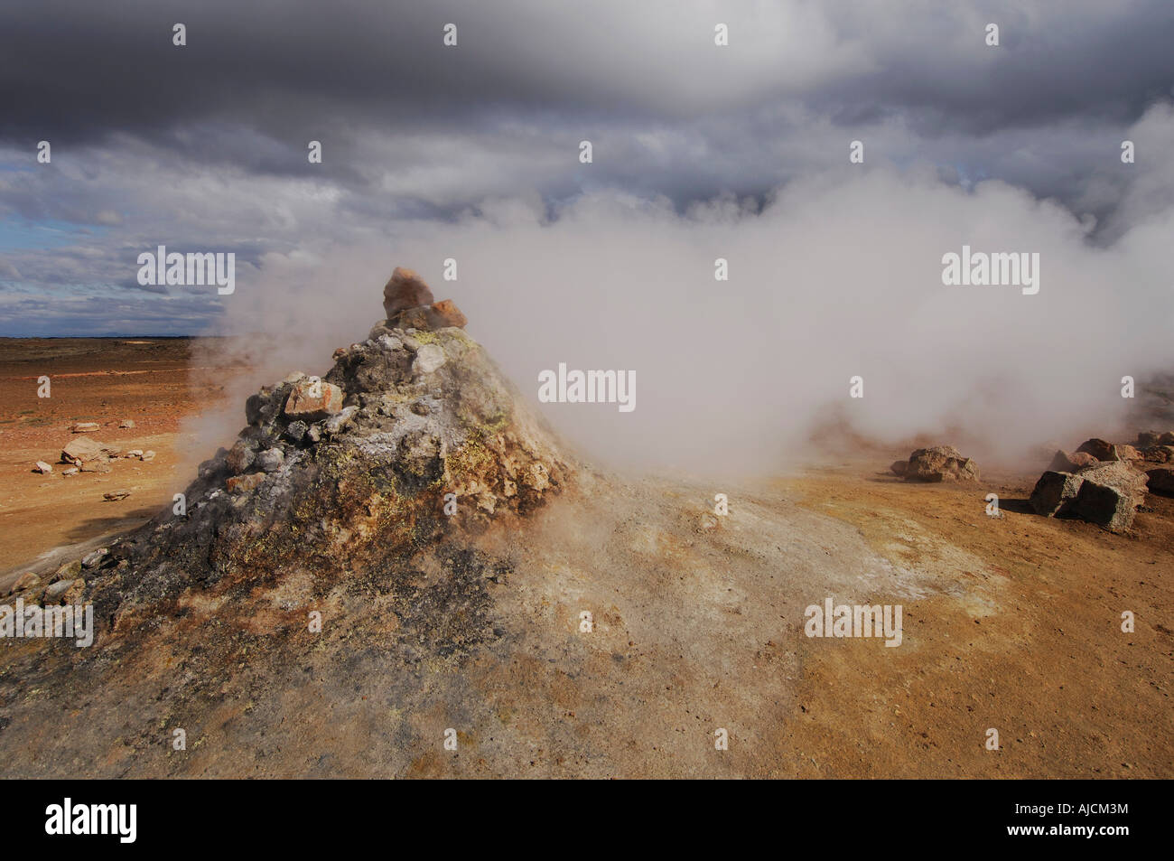 Steaming vent or fumarole in a geothermal landscape with a view of ...