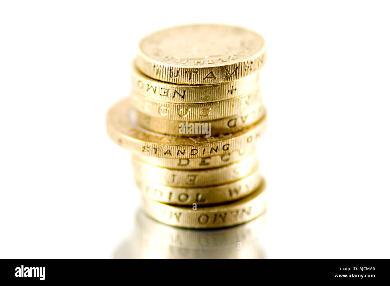 Stack of British One Pound coins with reflection against a white ...