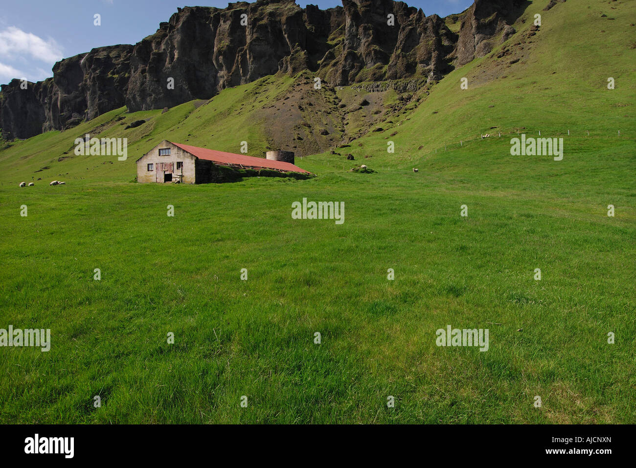 Barn or sheep shed beneath basalt crags near the farming township of ...