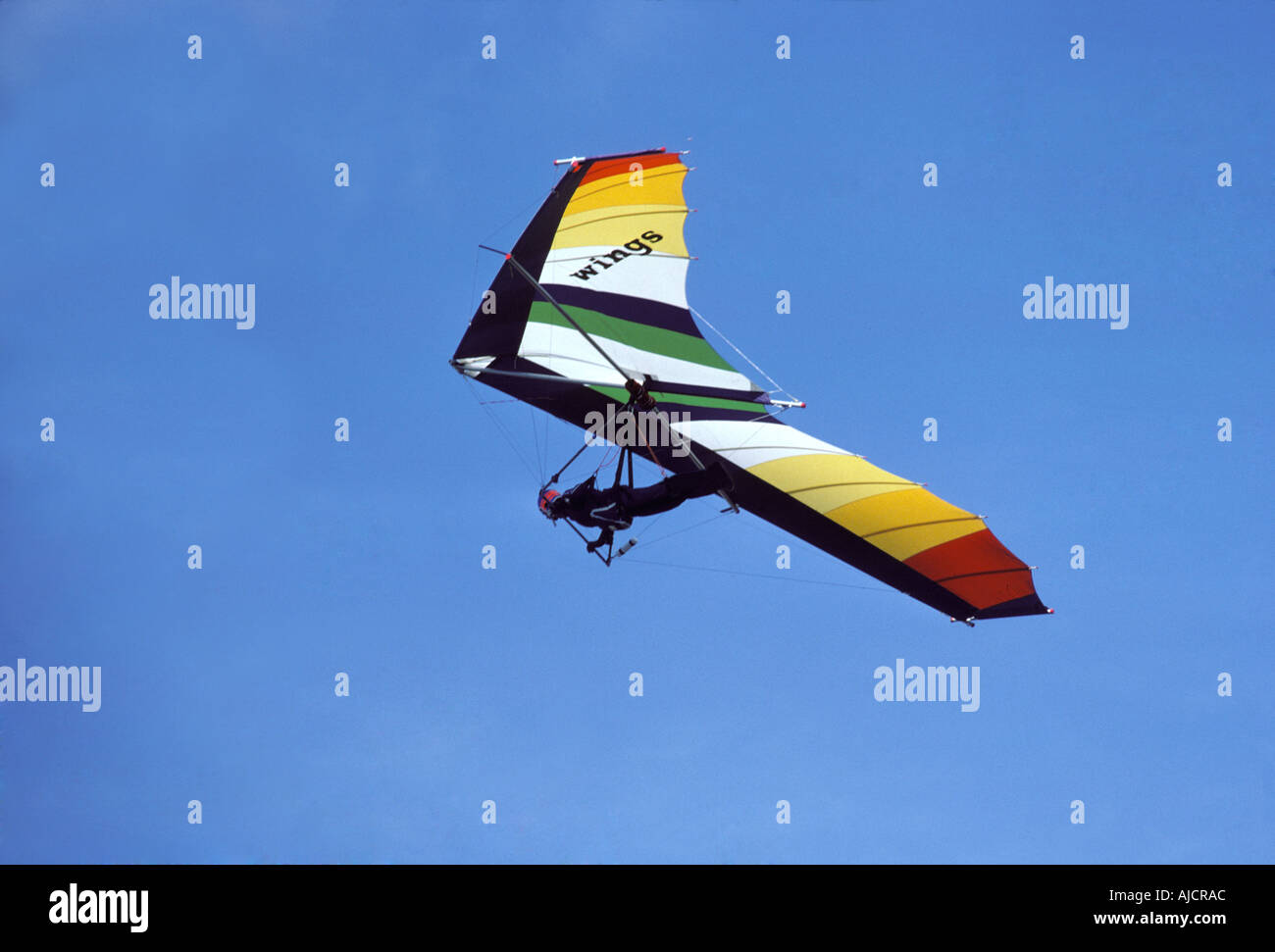 yellow black red green striped hang glider above Tegelberg mountain ...