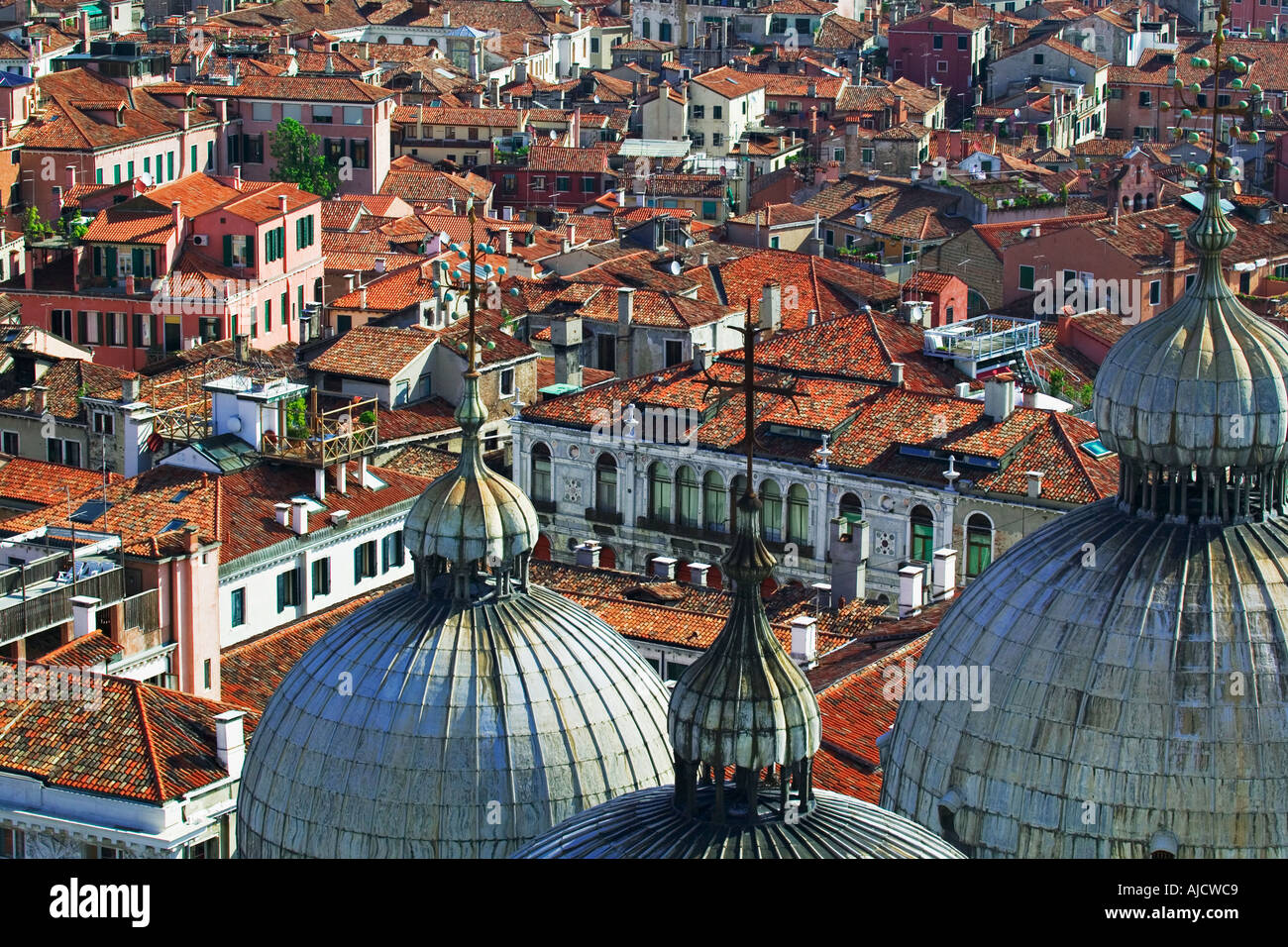 Red tile rooftops cover the city of Venice beneath the dome of Basilica ...