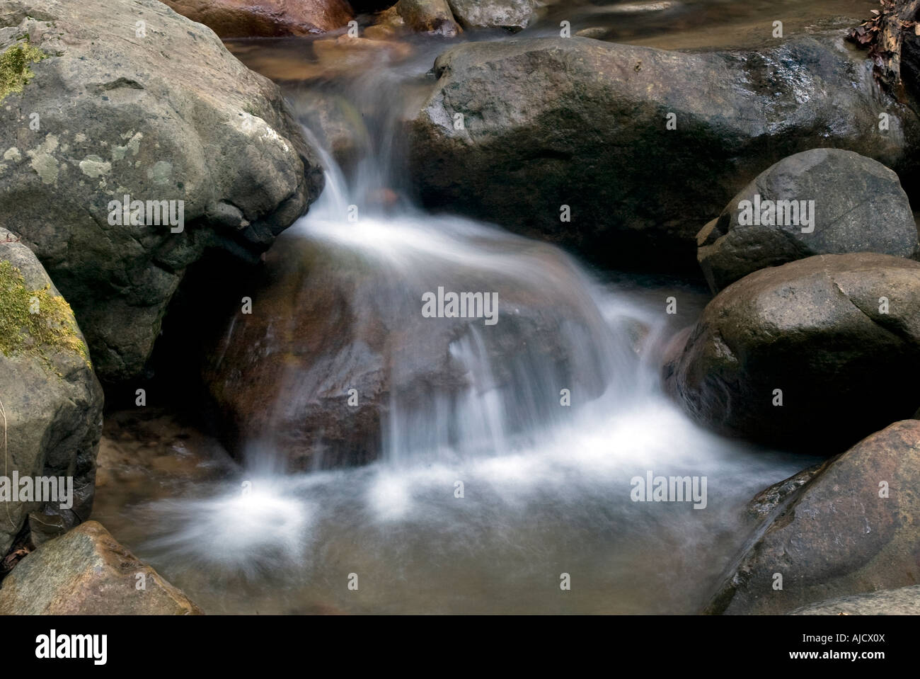 Waterfall running through rocks Stock Photo - Alamy