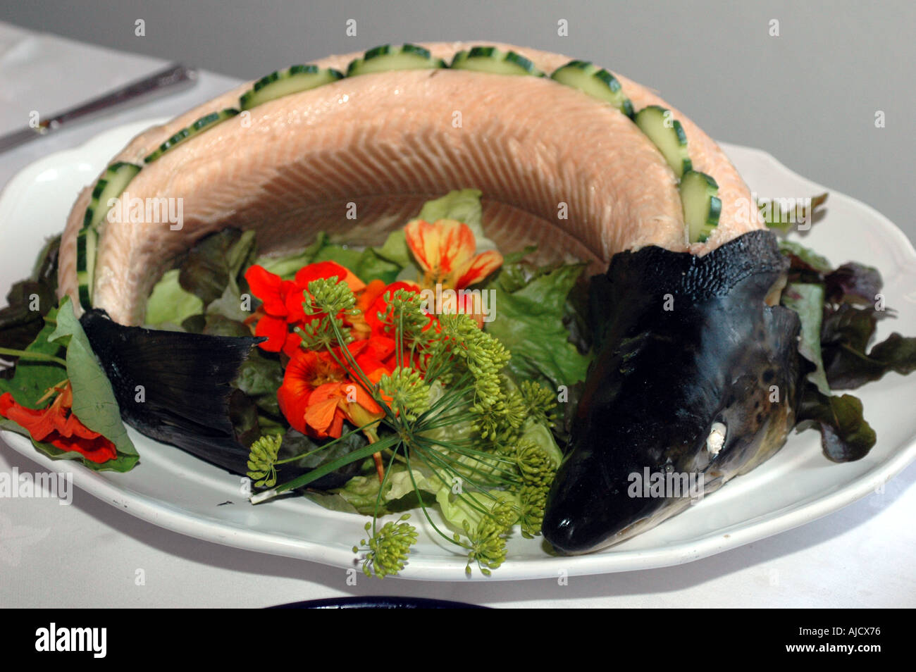 Baked whole salmon with flowers and salad Stock Photo - Alamy