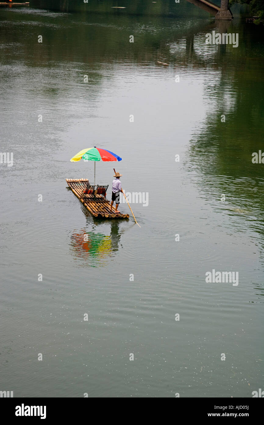 a boatman paddles his raft along the Yulong River in Guilin China Stock ...