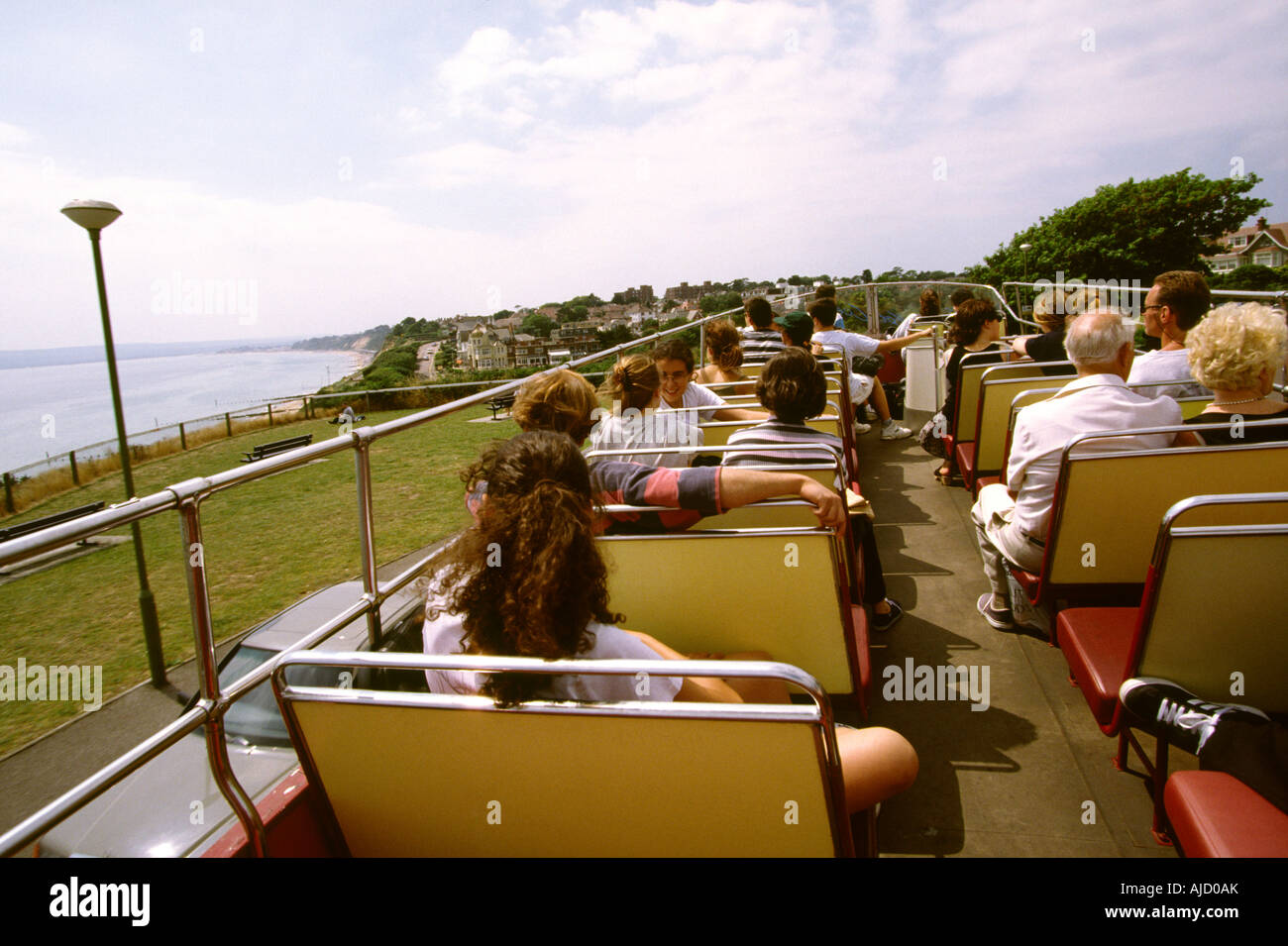 UK Dorset Bournemouth view of passengers from open topped bus on coast ...
