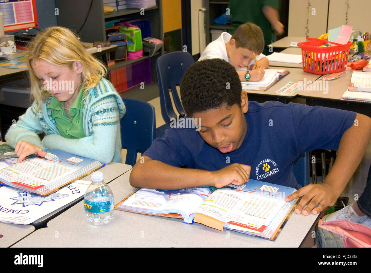 Fouth grade students read textbooks in a classroom at a public school ...