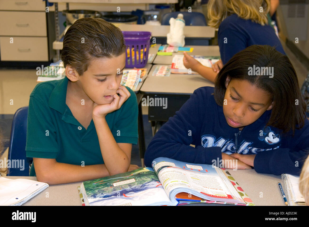 Fourth grade students read textbooks in a classroom at a public school ...
