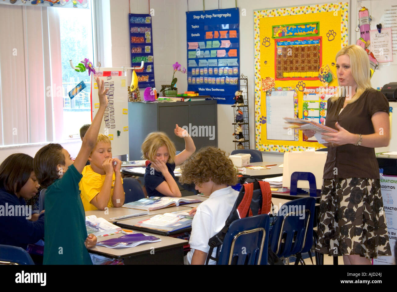 Teacher and fourth grade students in a classroom at a public school in ...
